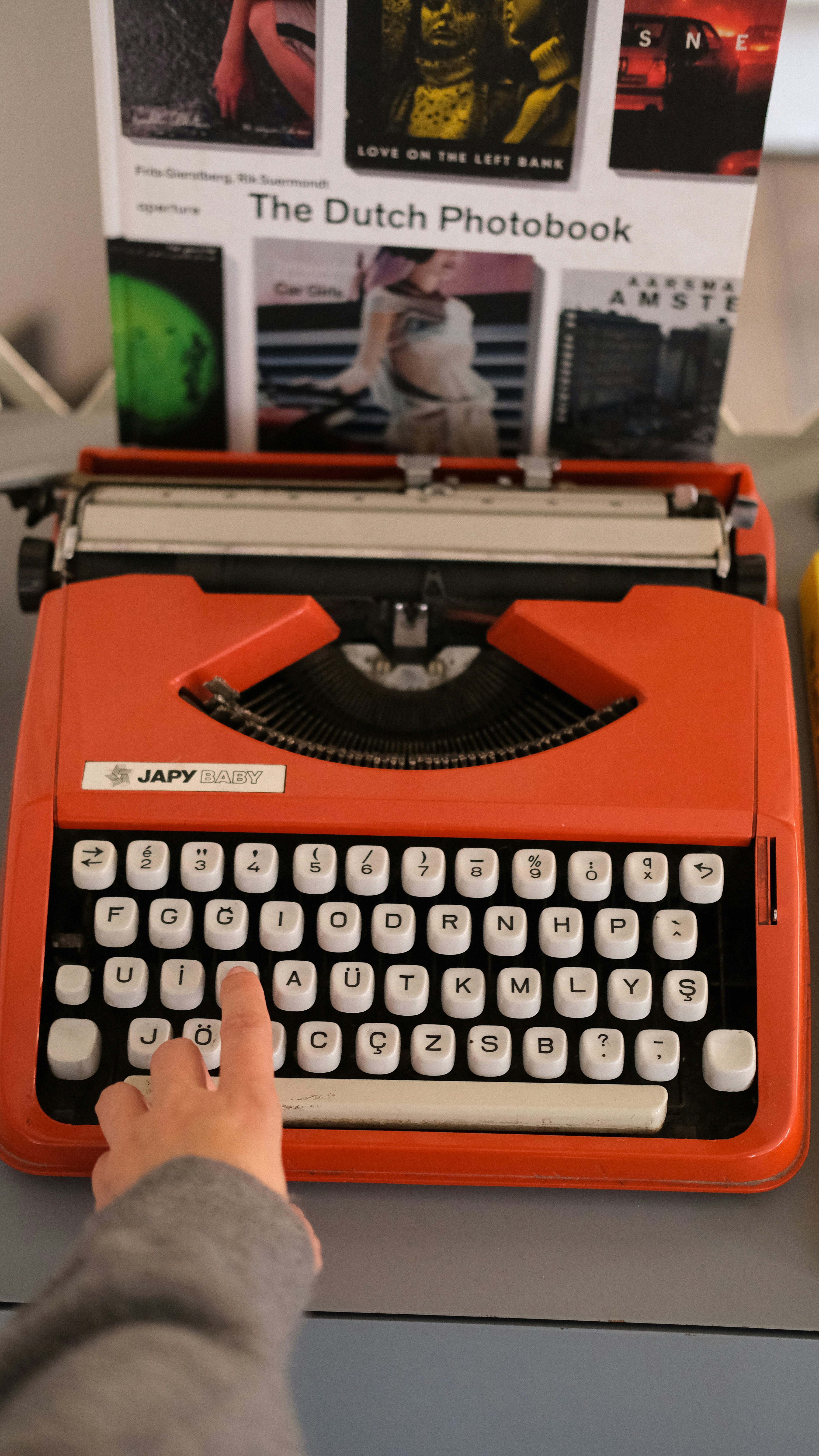 A person typing on an orange typewriter photo – Free Woman Image on ...
