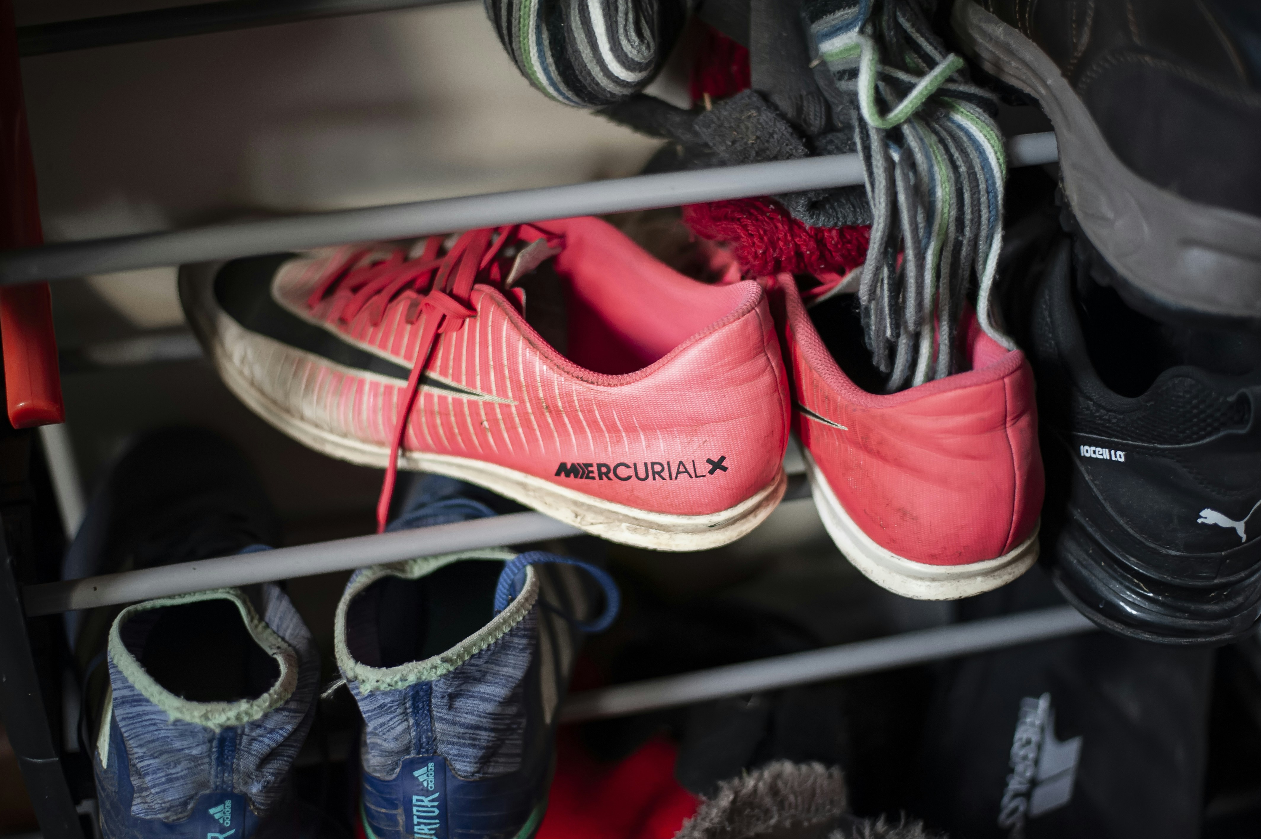 Scarlet Mercurial X on a Metal Shelf: A Quiet Clash of Colorful Boots