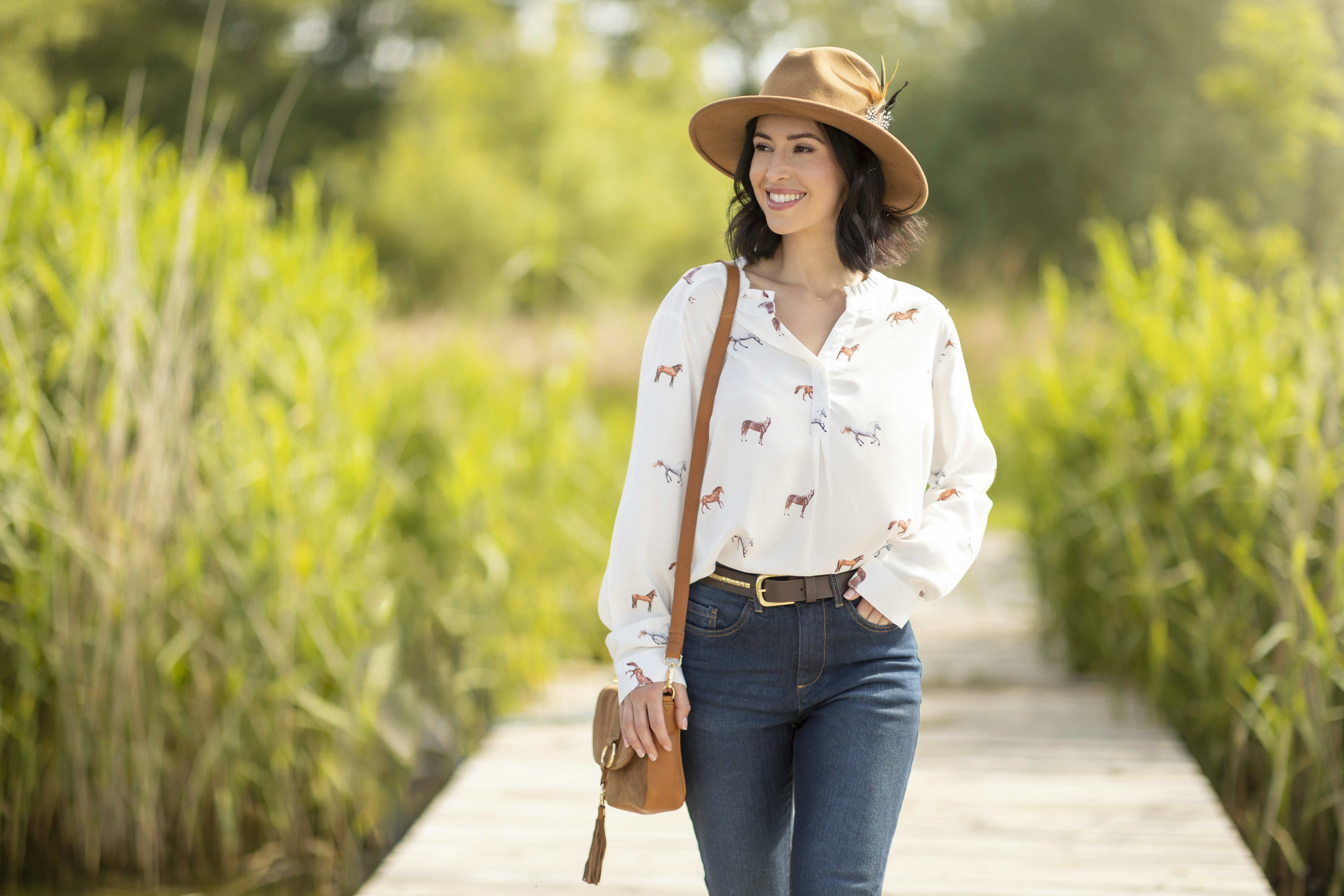 A woman in a hat is walking down a path photo – Free Woman Image on ...