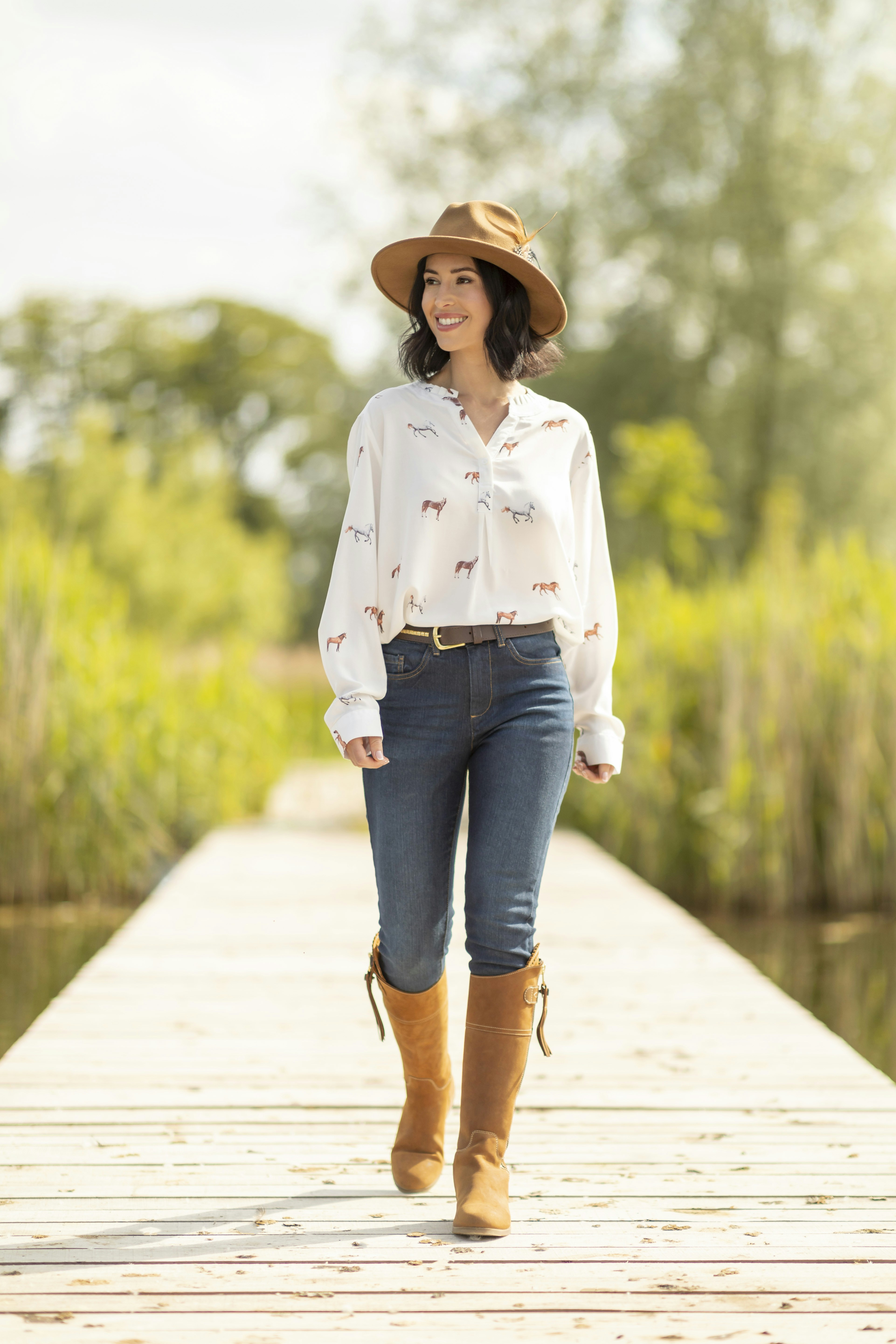 A woman in a cowboy hat is walking on a dock photo – Free Woman Image ...