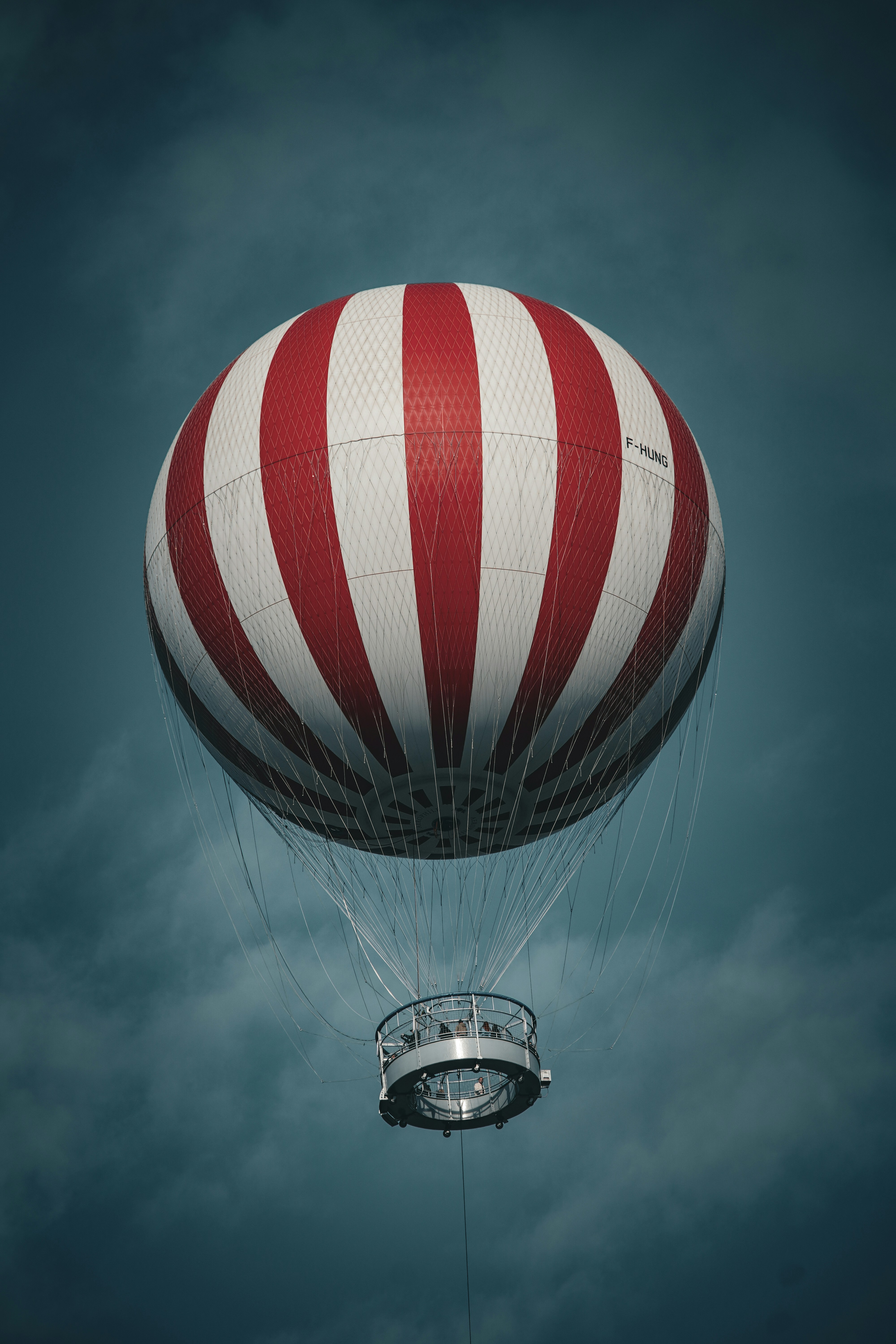 Red-Striped Balloon Drifts Quietly Across a Turquoise Sky