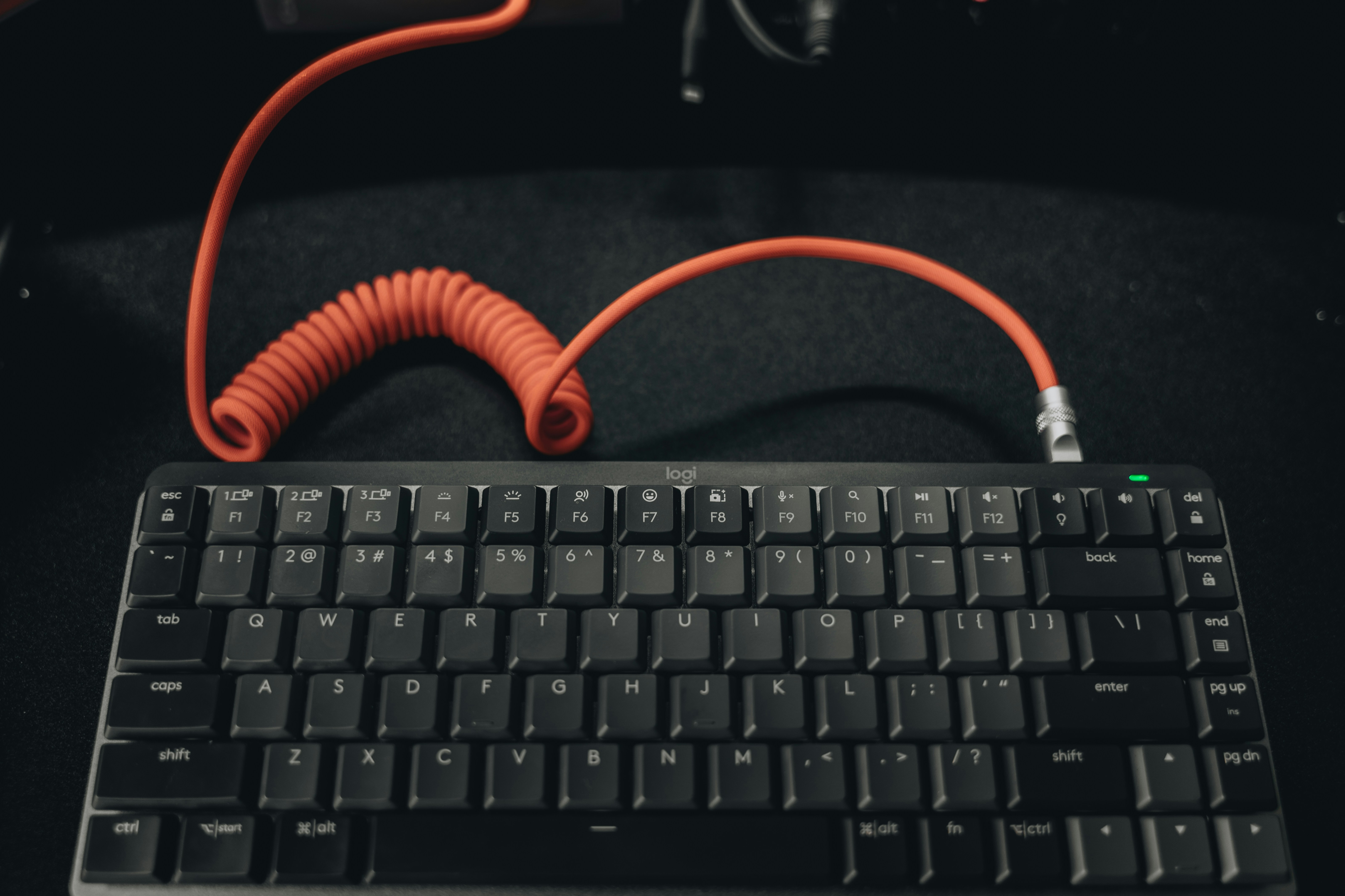 Crimson Coil Arches Over a Quiet Keyboard