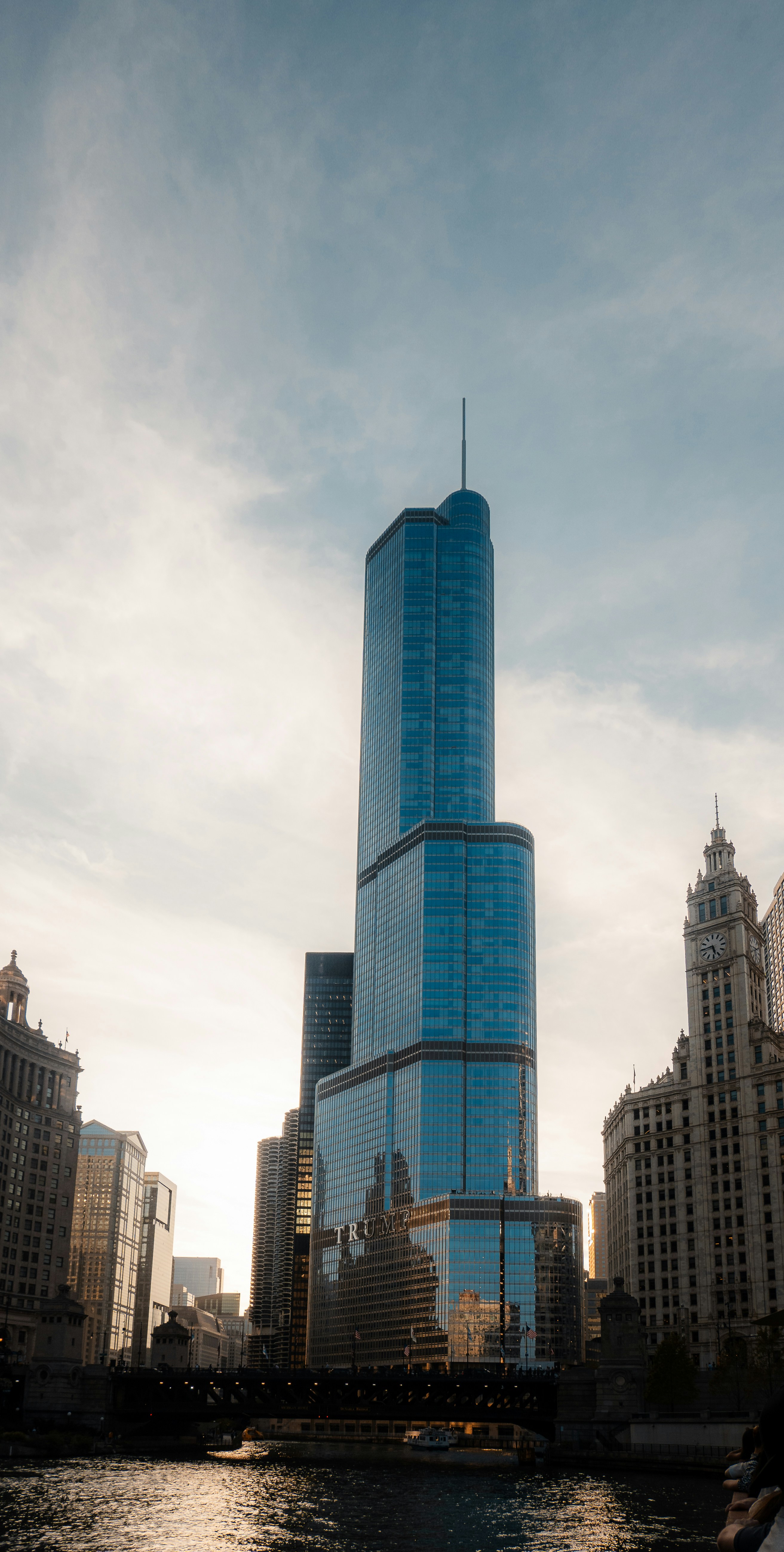 A tall building towering over a city next to a body of water photo ...
