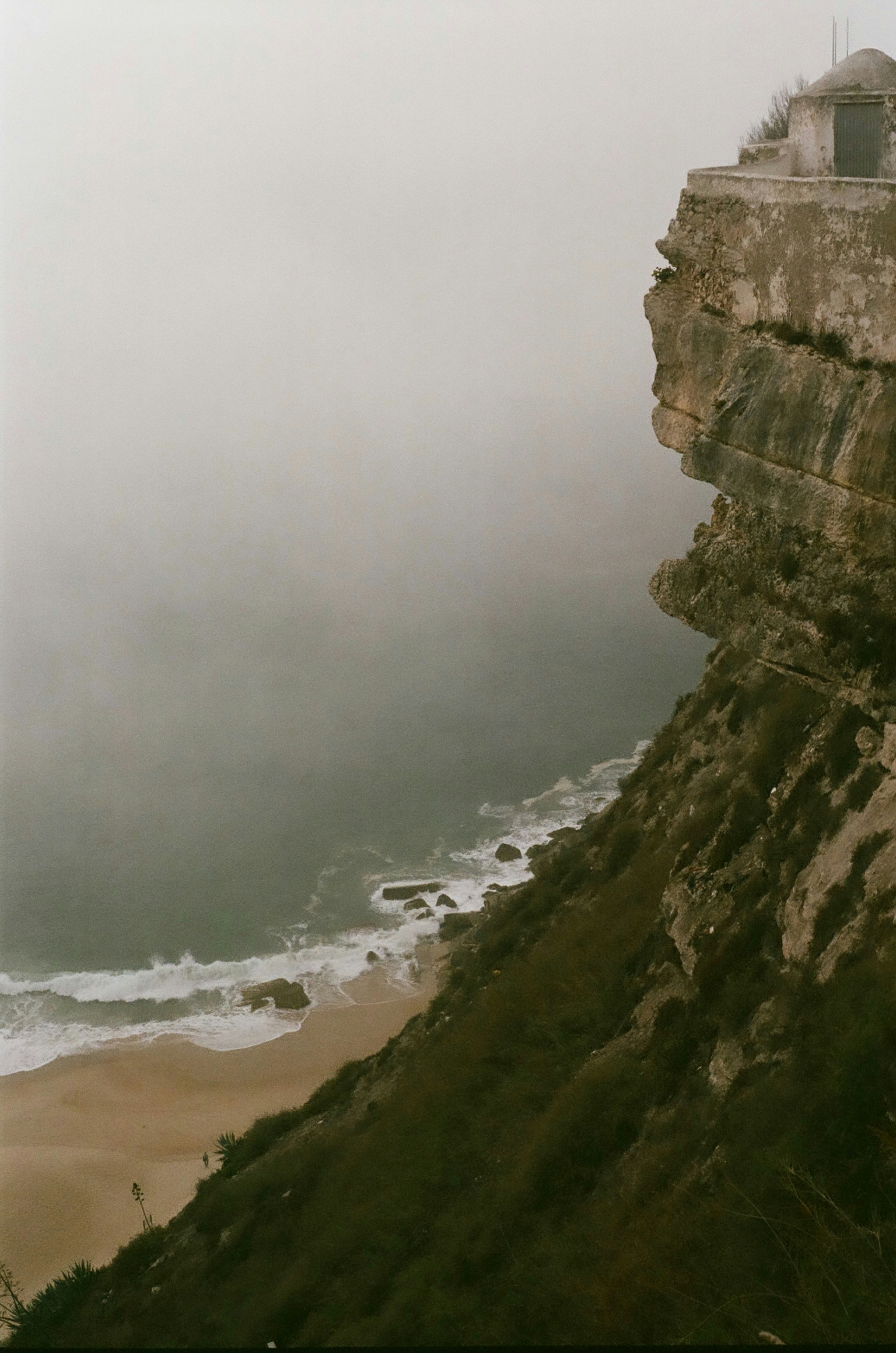 A lighthouse on a cliff overlooking the ocean photo – Free Nazaré Image ...
