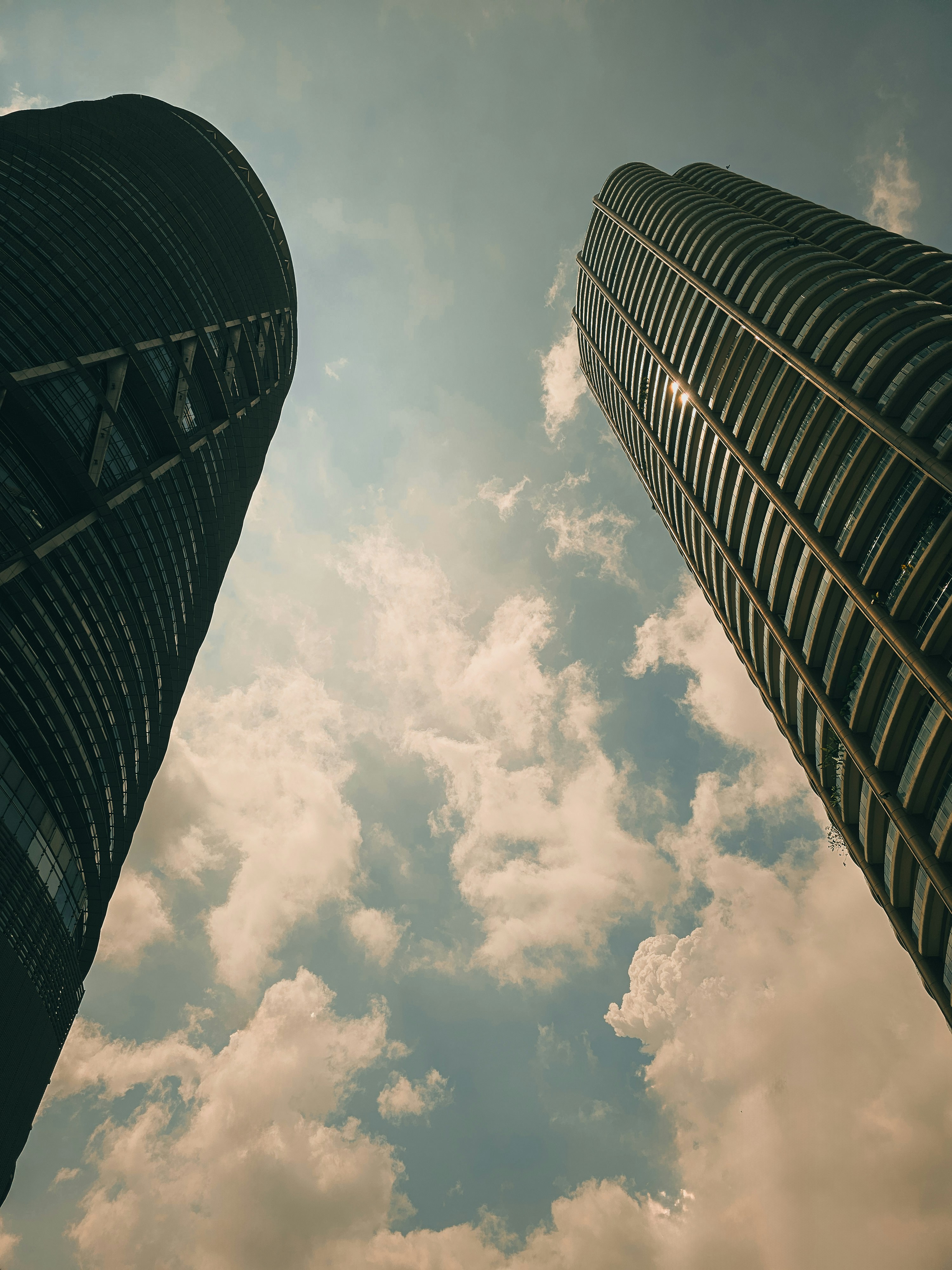 Looking up at two tall skyscrapers against a cloudy sky photo – Free ...
