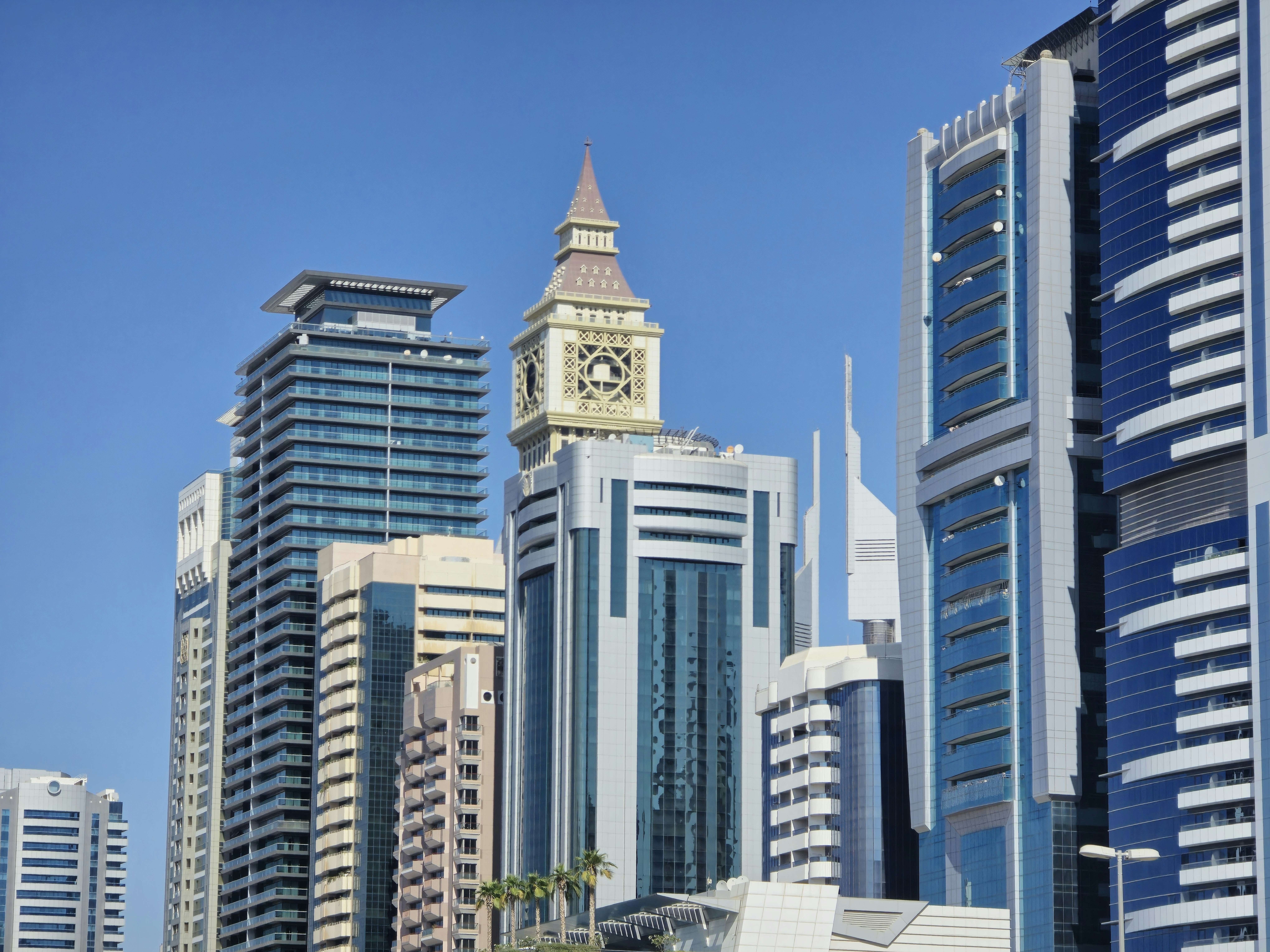 A city with tall buildings and a clock tower photo – Free Dubai ...