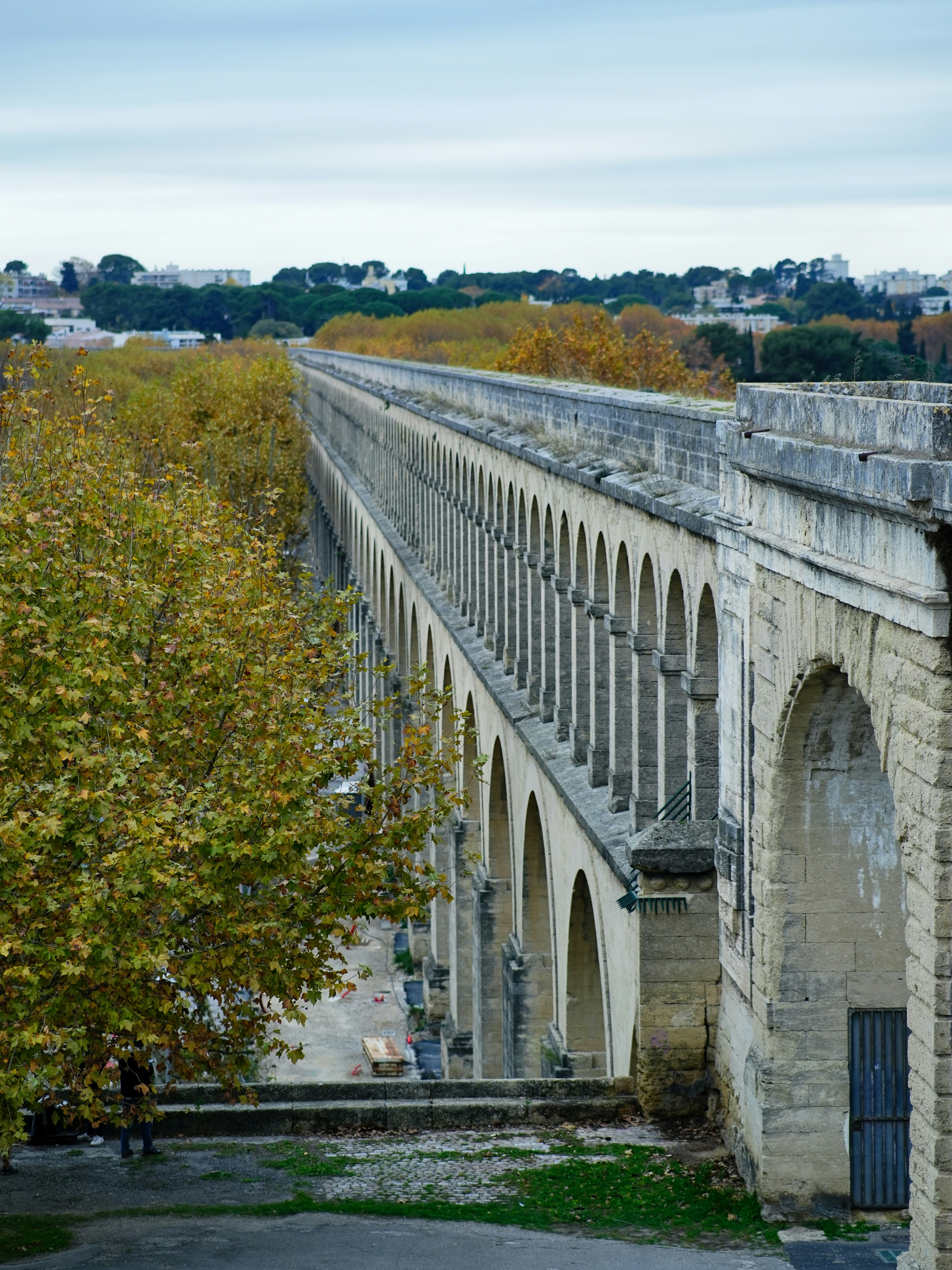 Autumn Arches: A Time-Worn Aqueduct Reaching Toward the Horizon