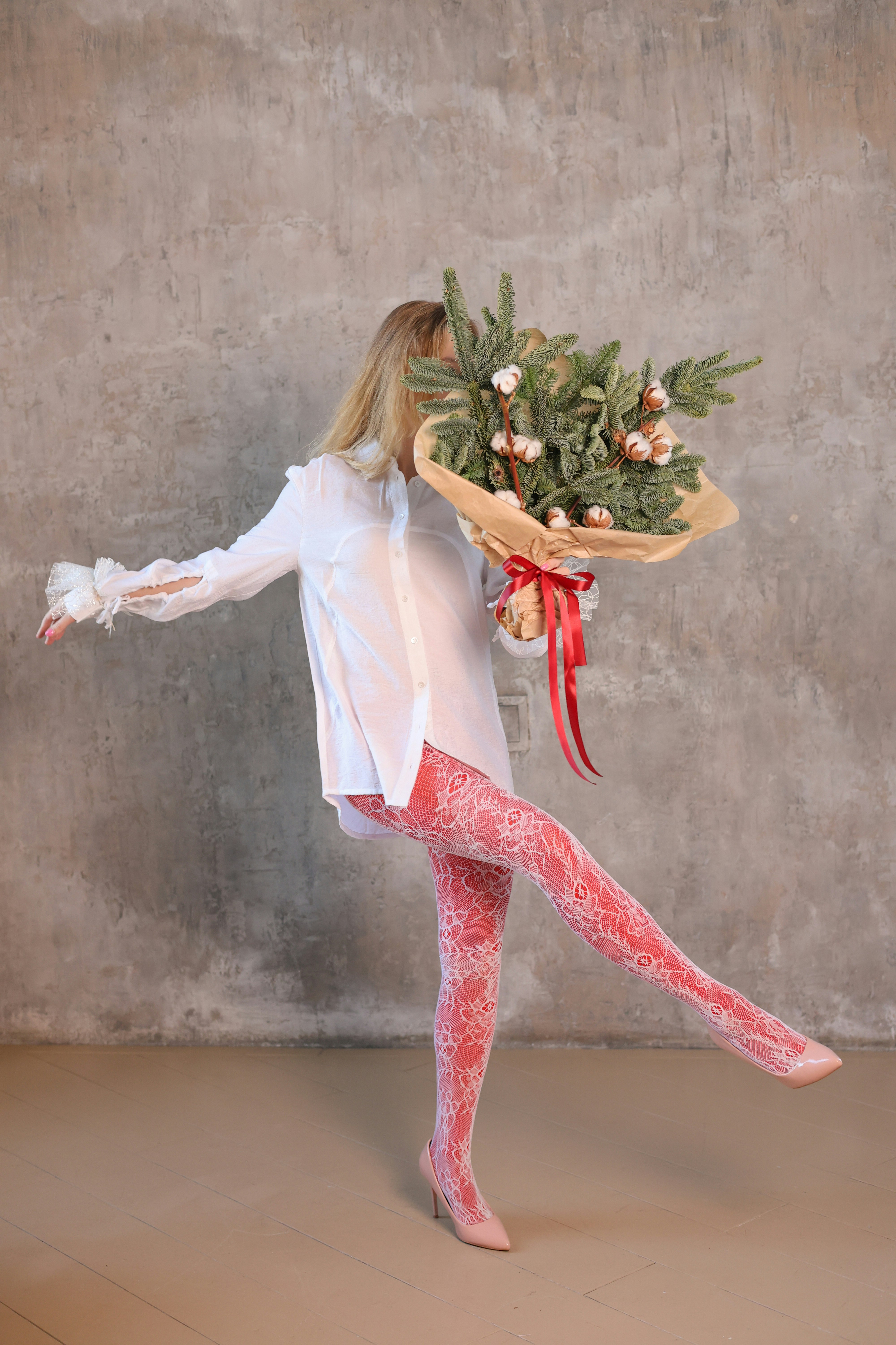 Blooms in Motion: a bouquet-bearing dancer balances against a concrete backdrop