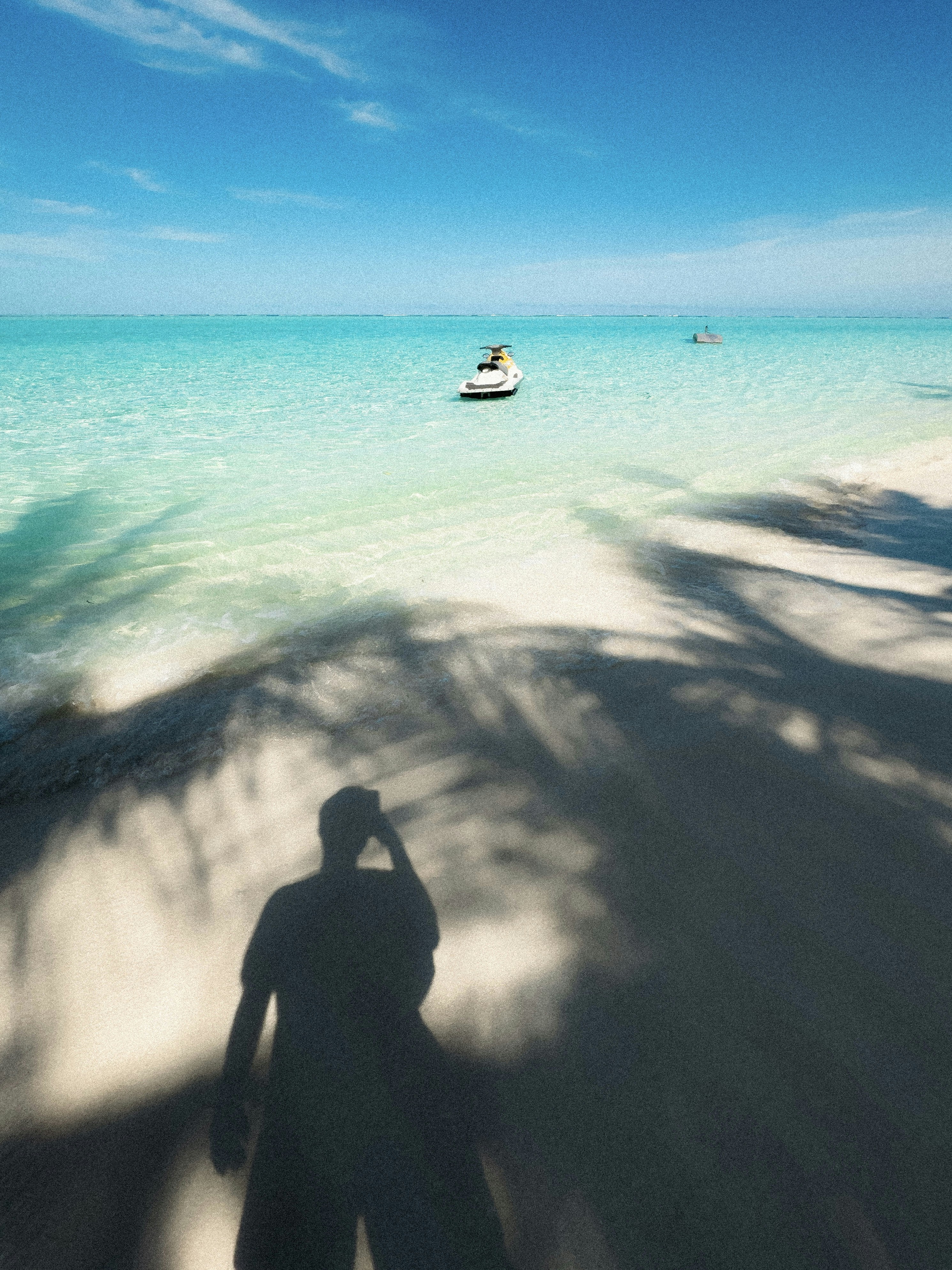 Turquoise Shoreline: Jet Ski and the Shadowed Calm