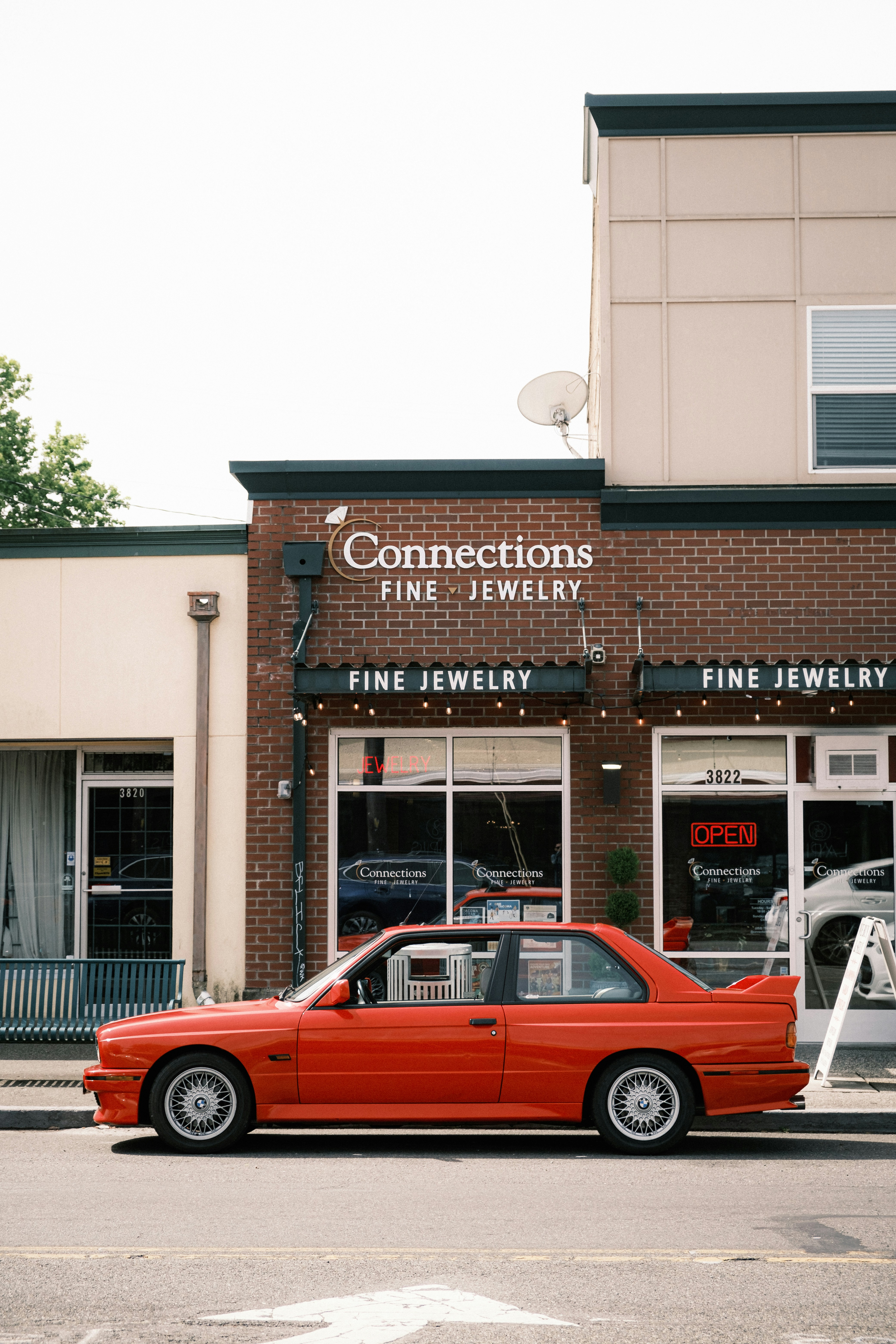 Red Convertible Grounded in a Brick-Bordered Jewelry Stop