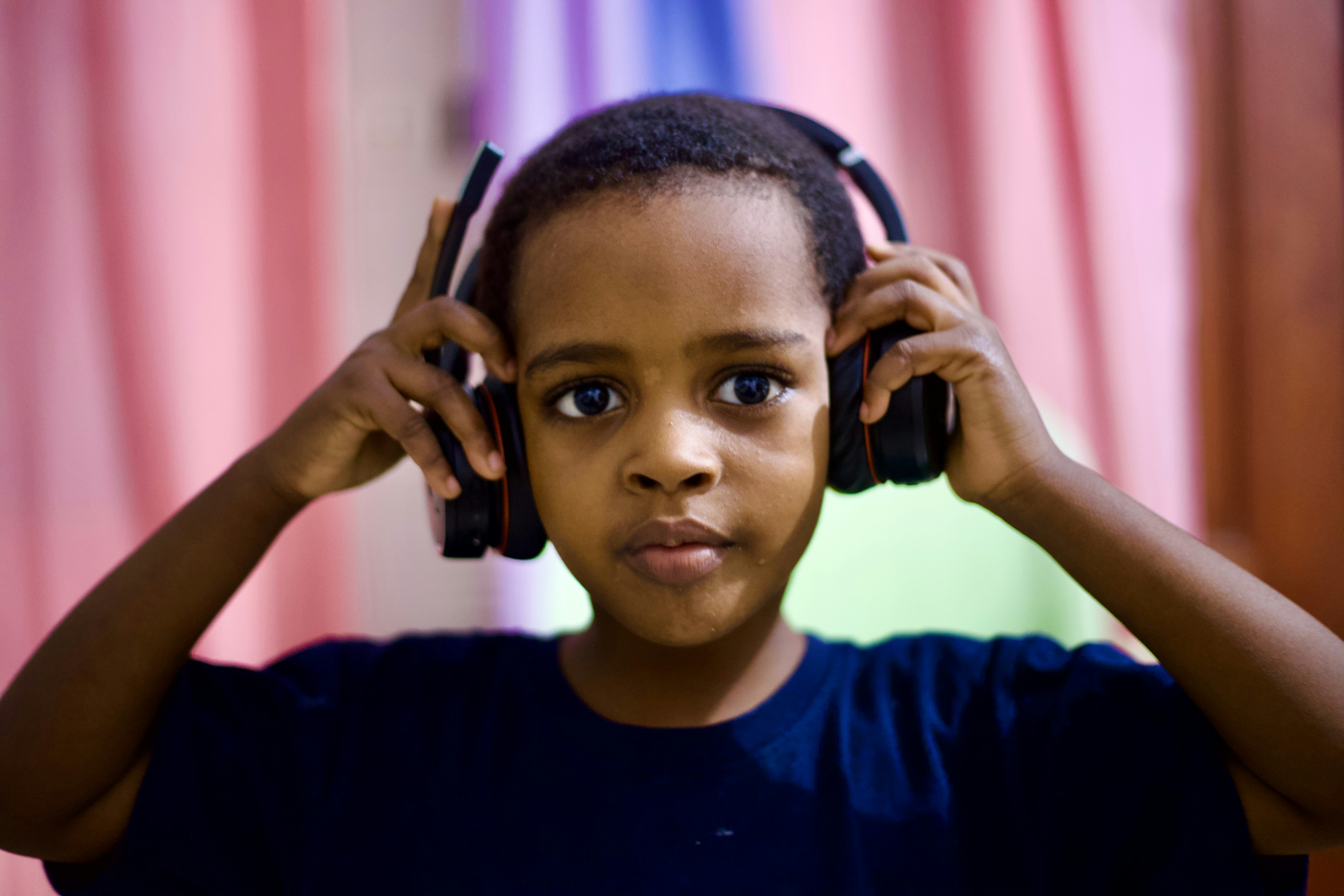 A young boy listening to headphones in a room