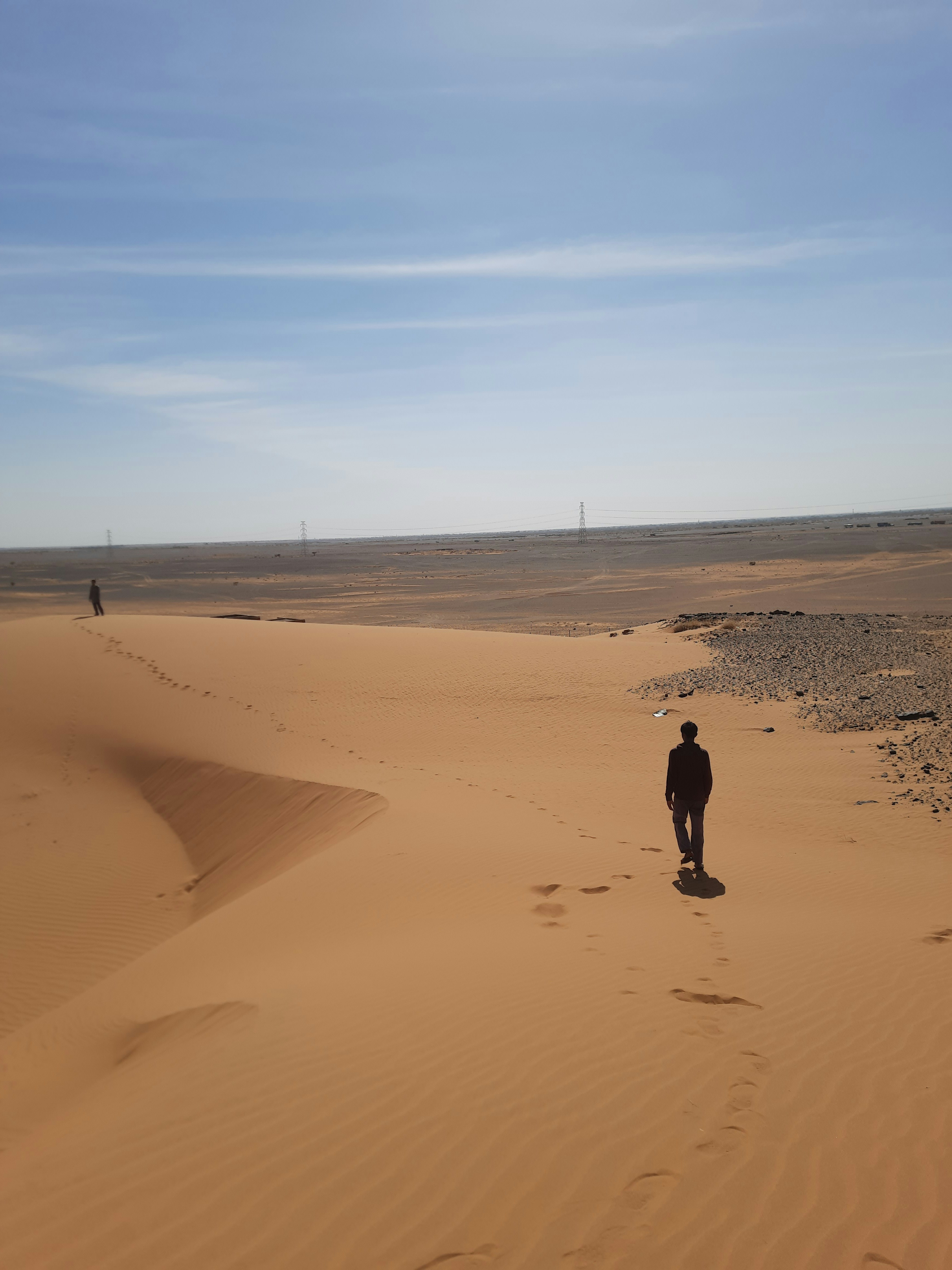 A man walking across a sandy field in the desert photo – Free Sudan ...
