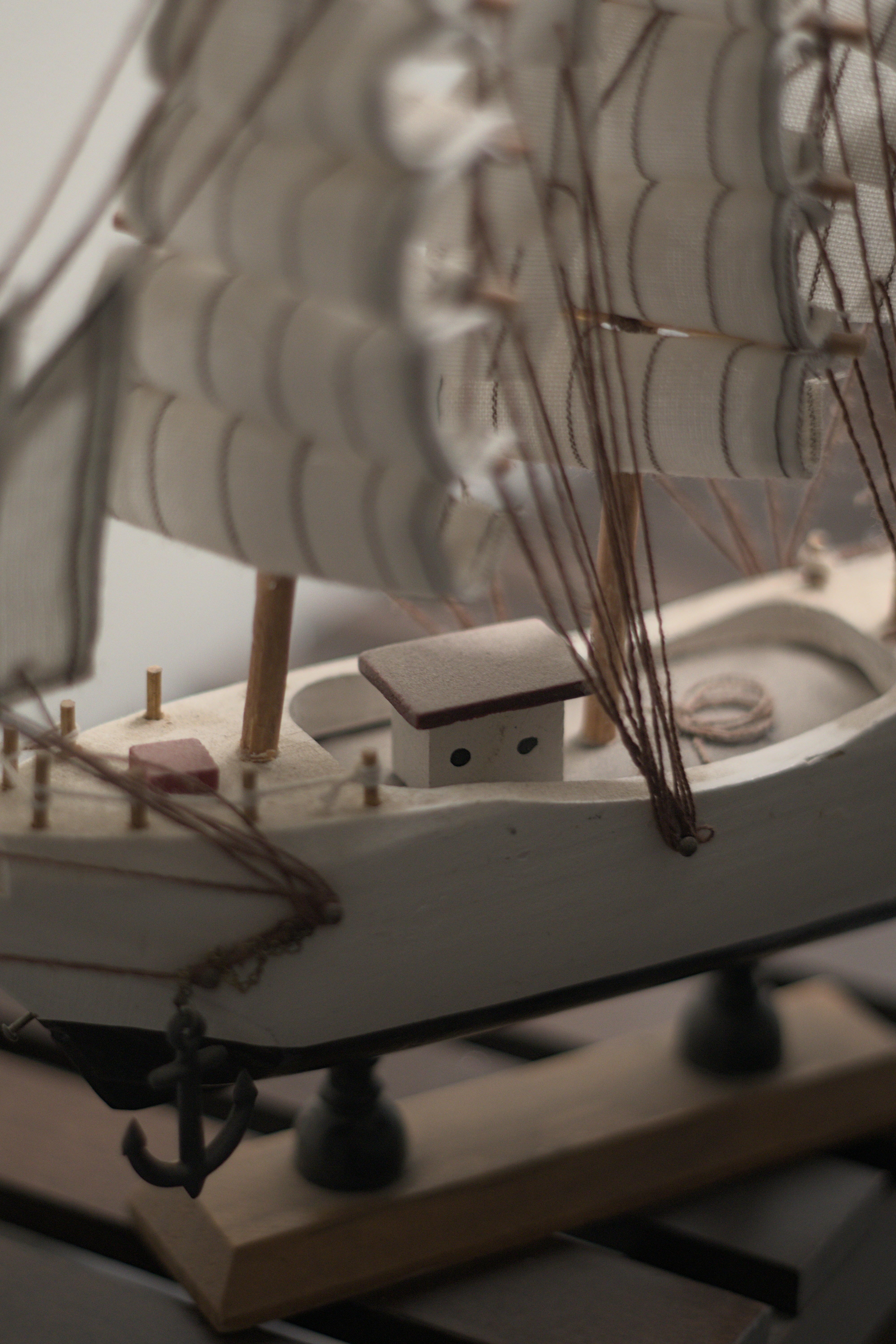 Sailing Miniature: A Sailboat's Quiet Moment on a Wooden Stand