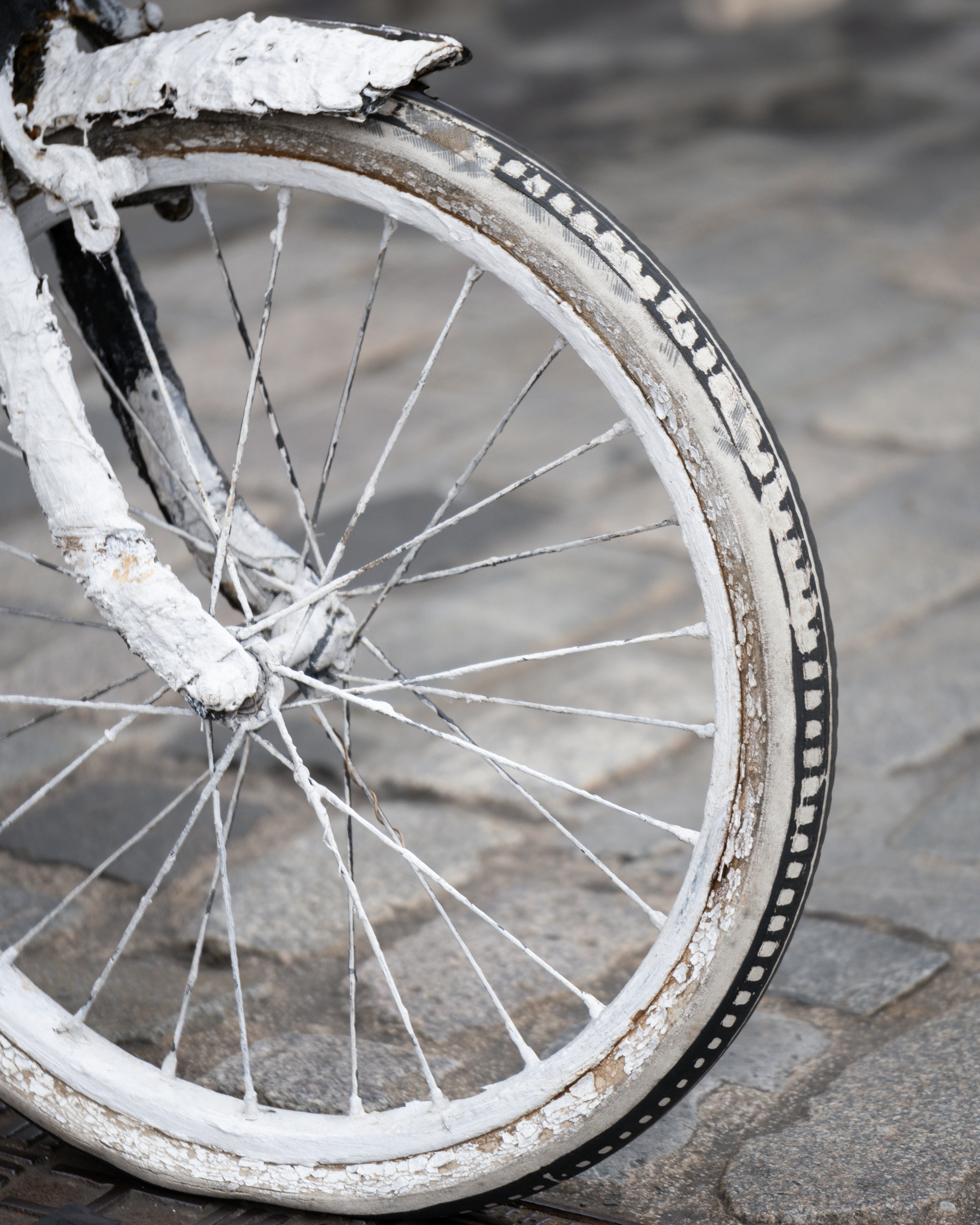 Frosted Spokes: An Ice-Crusted Bicycle Wheel on Cobblestones