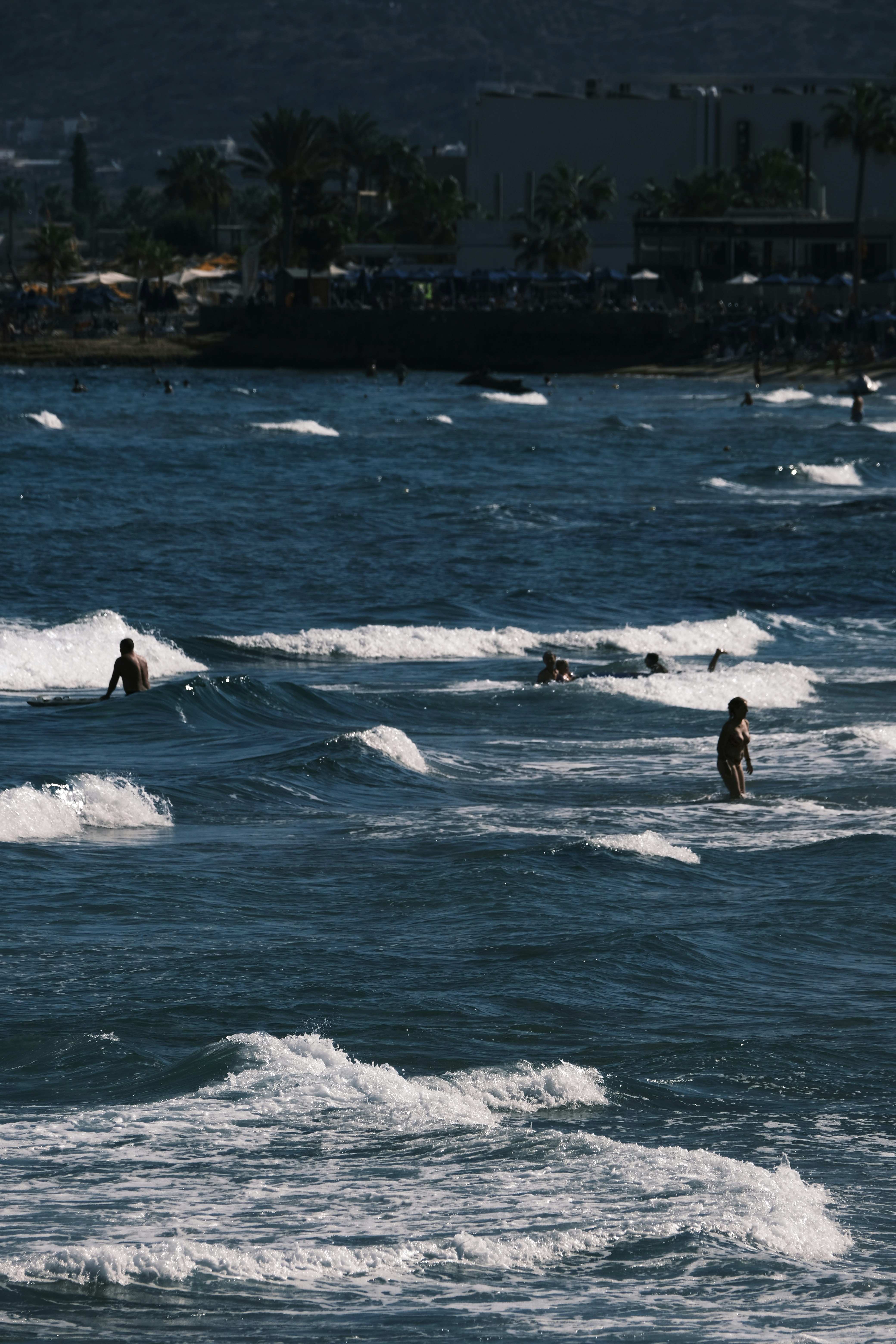 A group of people riding waves on top of surfboards photo – Free ...
