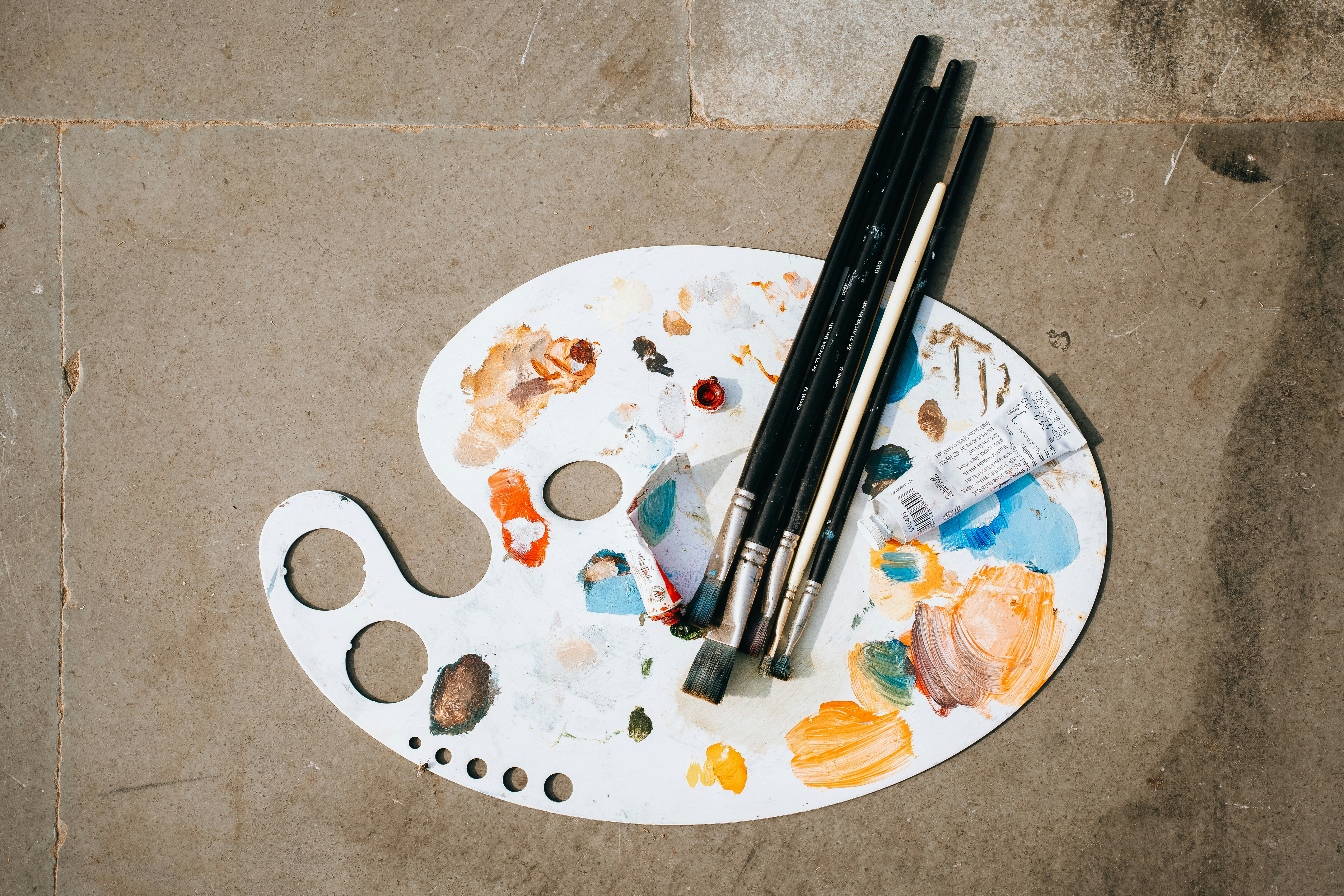 Palette Tools at Rest: Brushes on a Weathered Artist's Palette