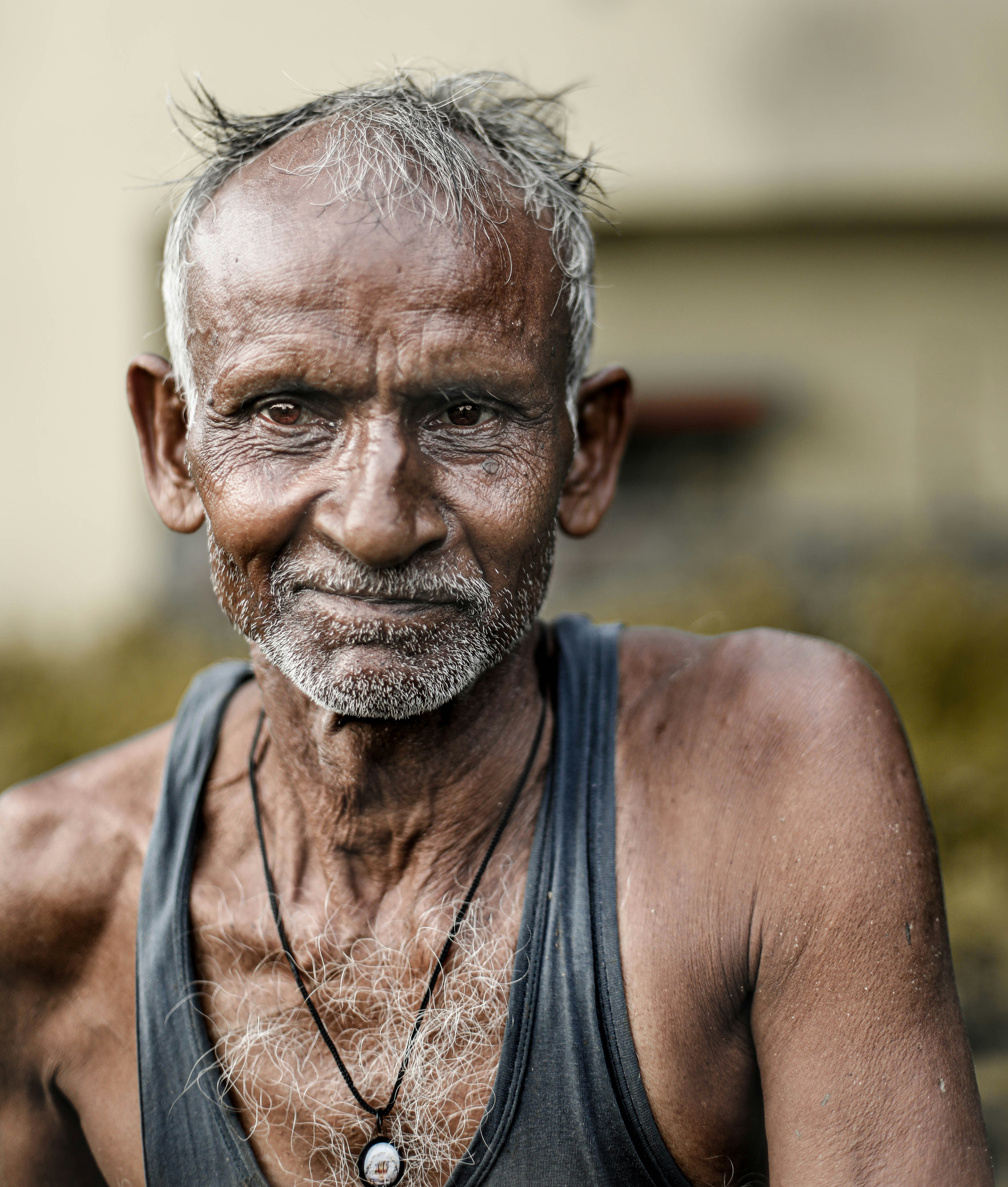 Elderly man with a weathered face and silver hair, showcasing deep lines of experience. Natural light accentuates his thoughtful expression.