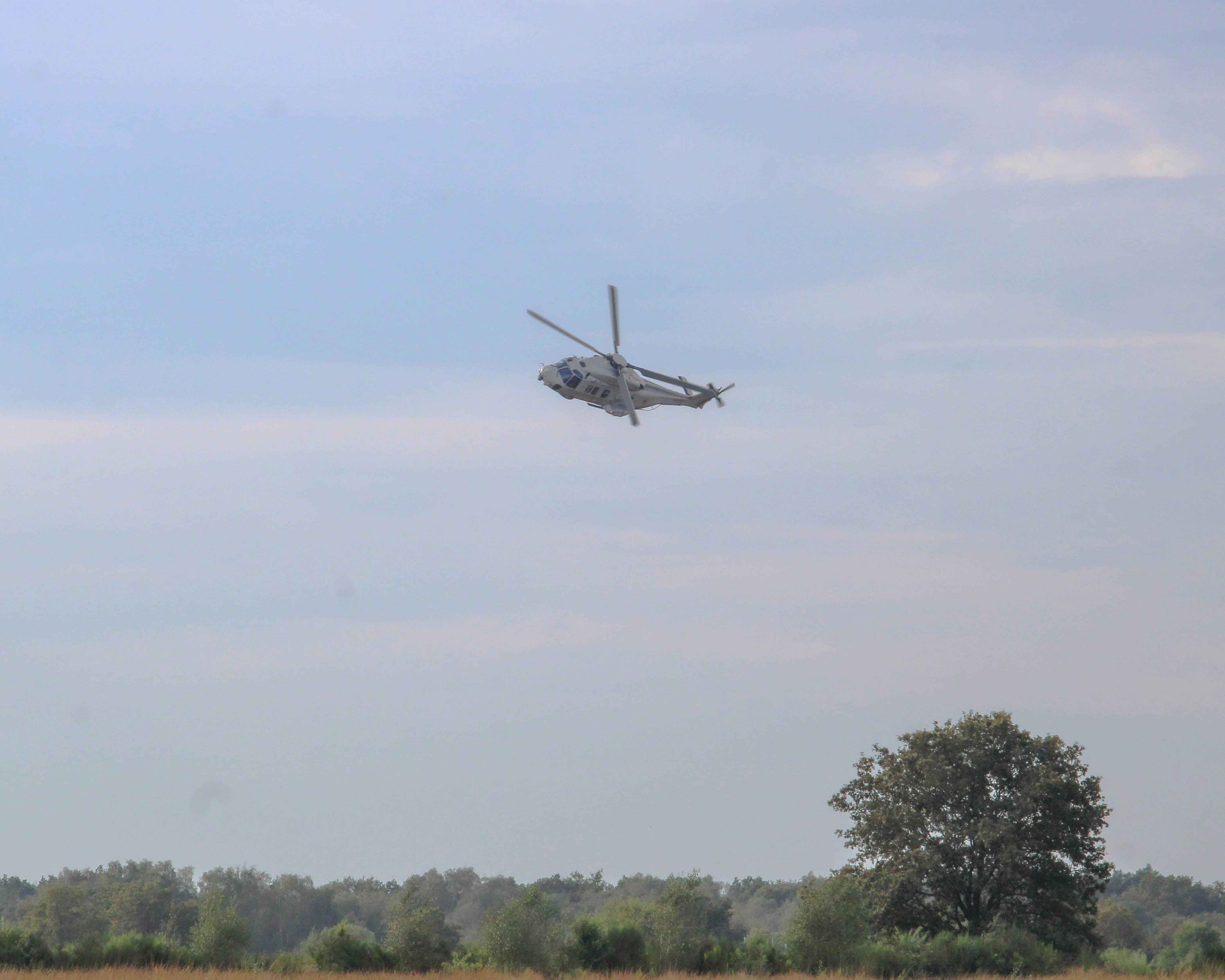 A helicopter flying over a field of grass photo – Free Military Image ...