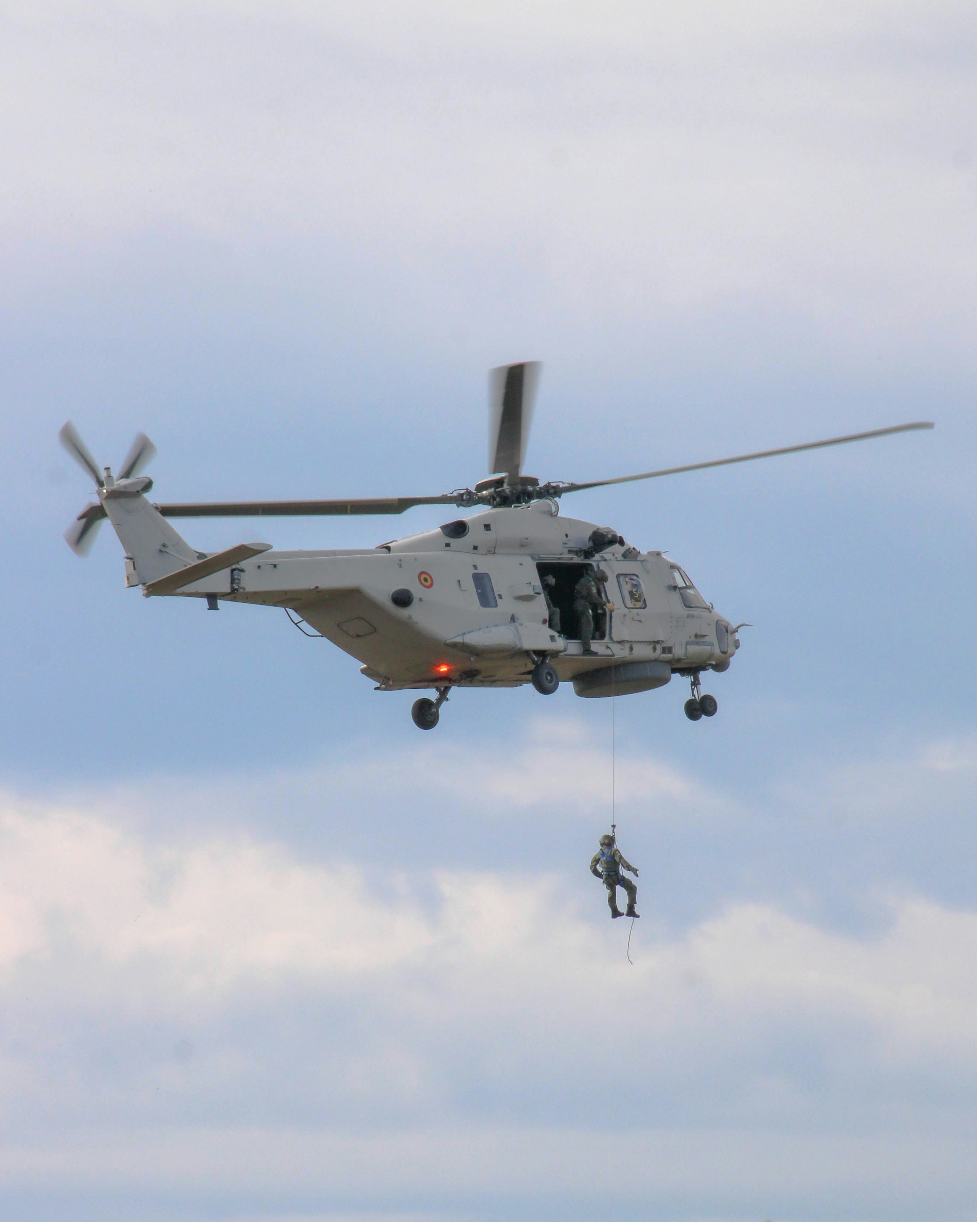 A man is being lifted from a helicopter by a parachute photo – Free ...