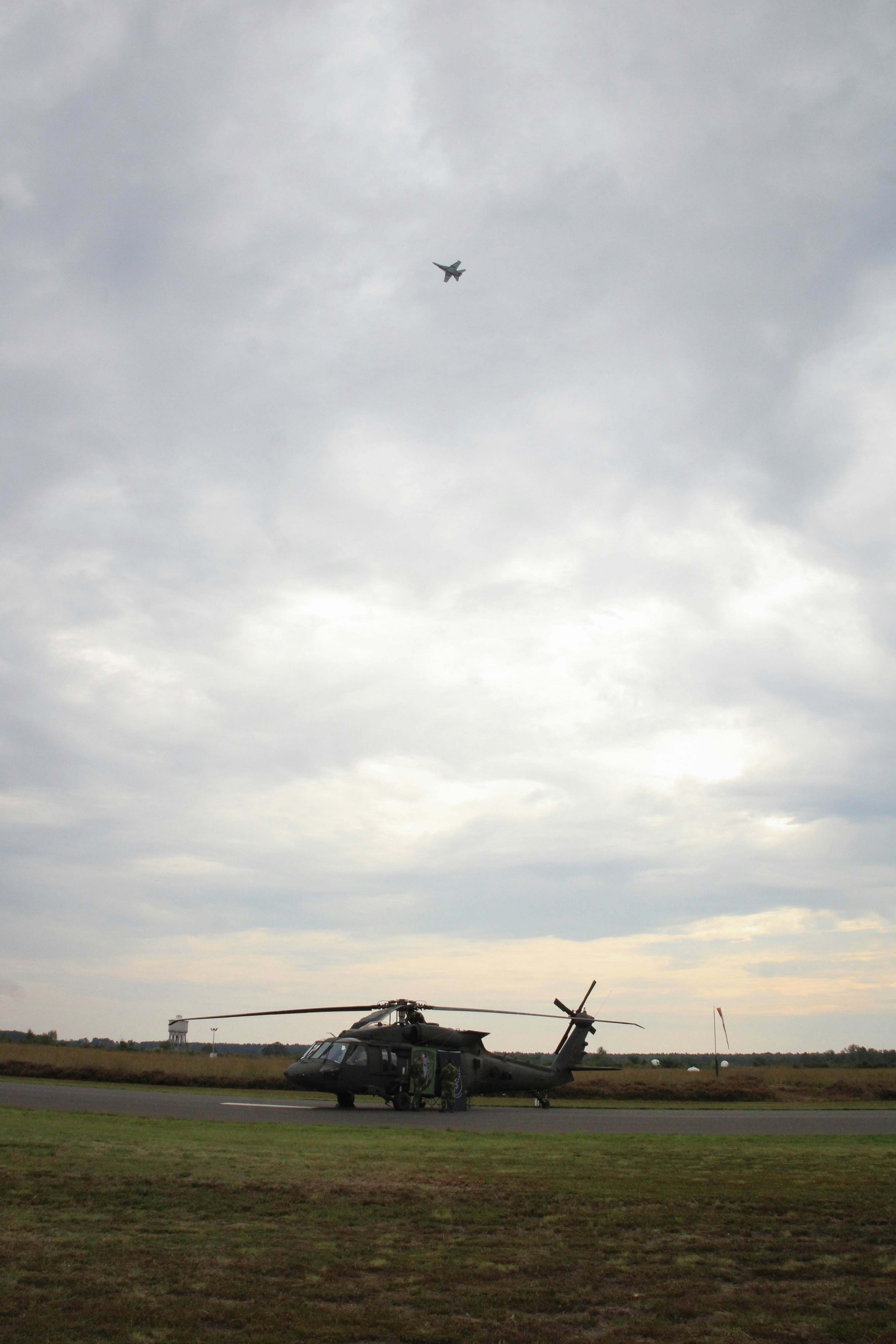 A military helicopter on a runway under a cloudy sky photo – Free Human ...