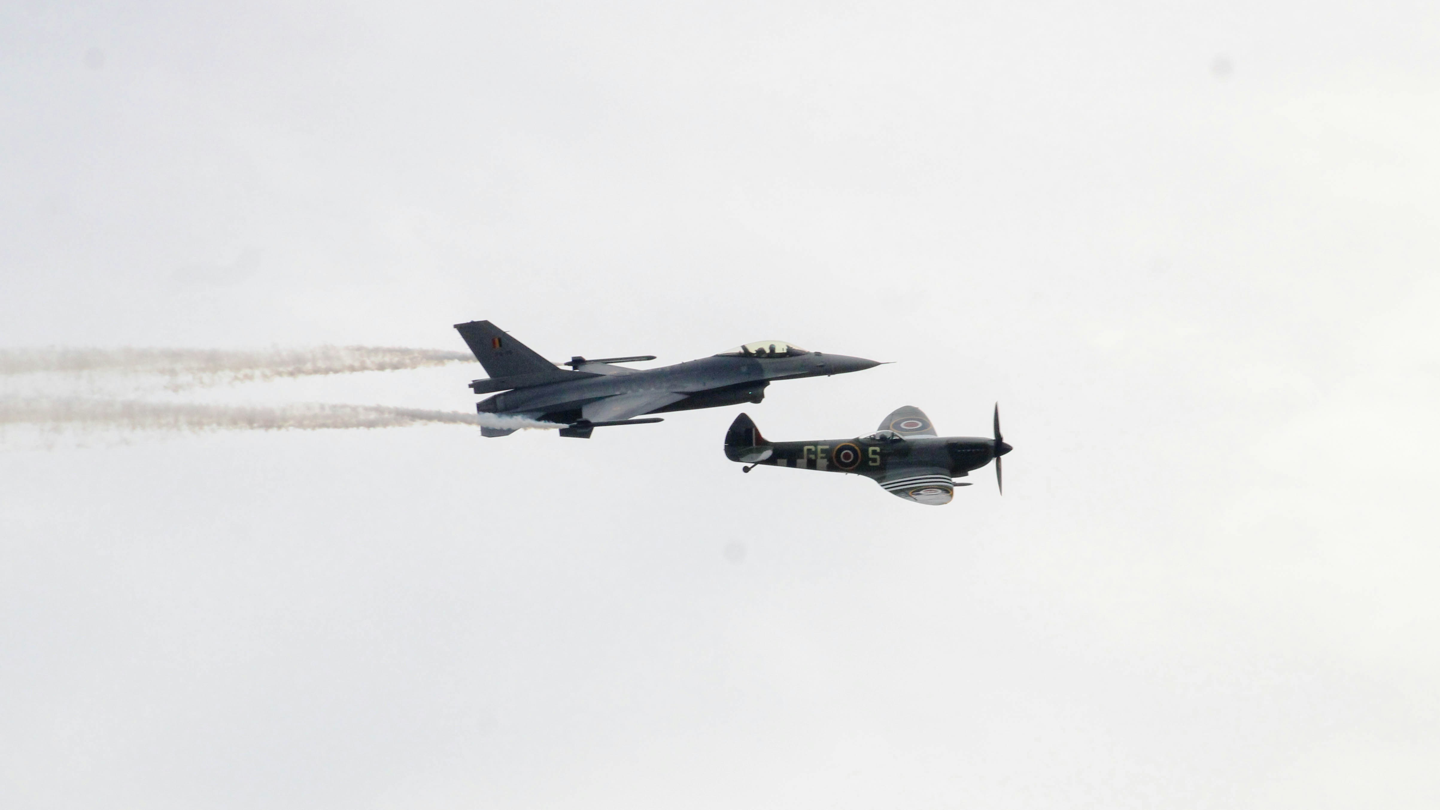 Two planes flying in the sky with smoke coming out of them photo – Free ...