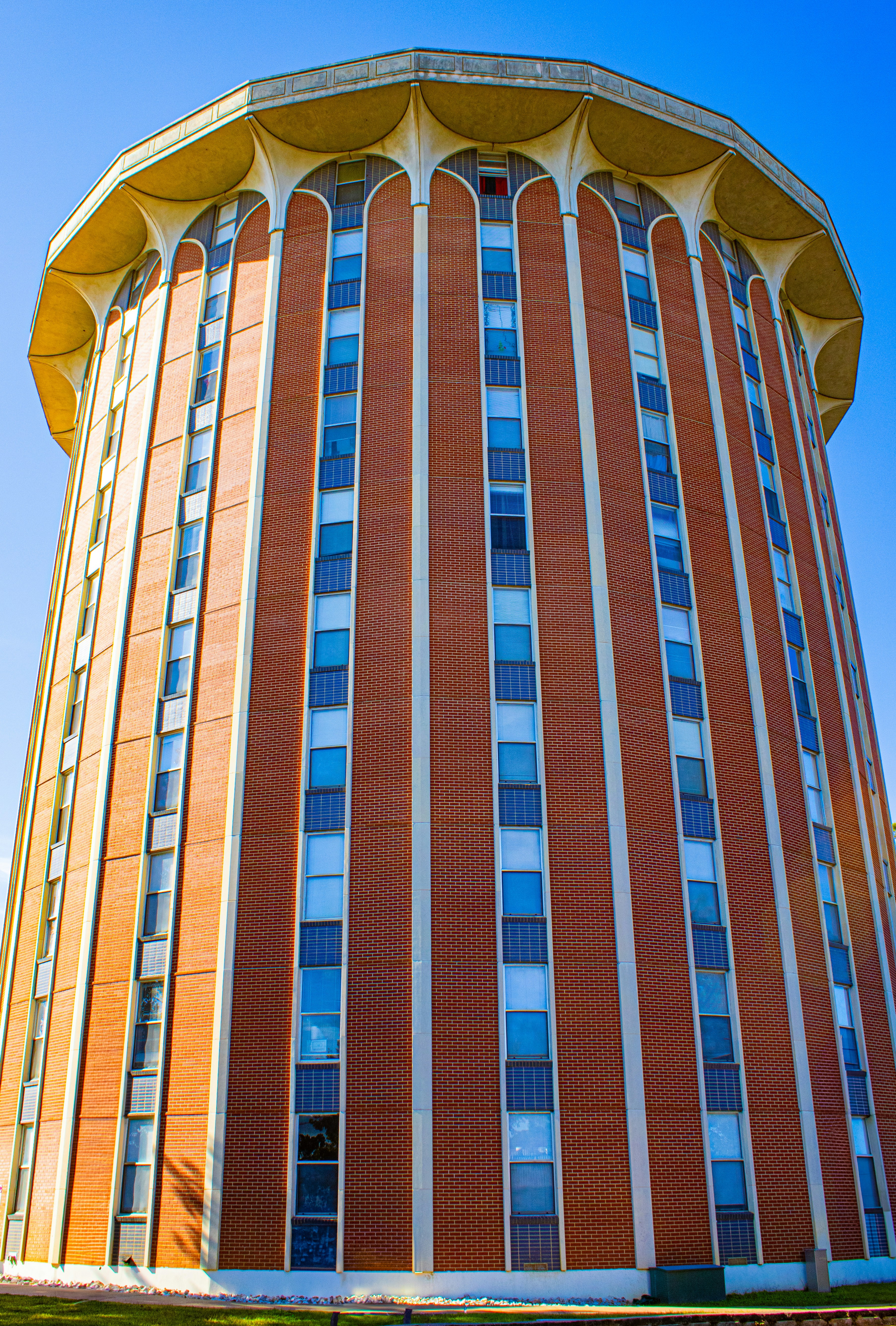 Cylindrical Brick Tower: Sunlit Stripes Against a Clear Blue Sky