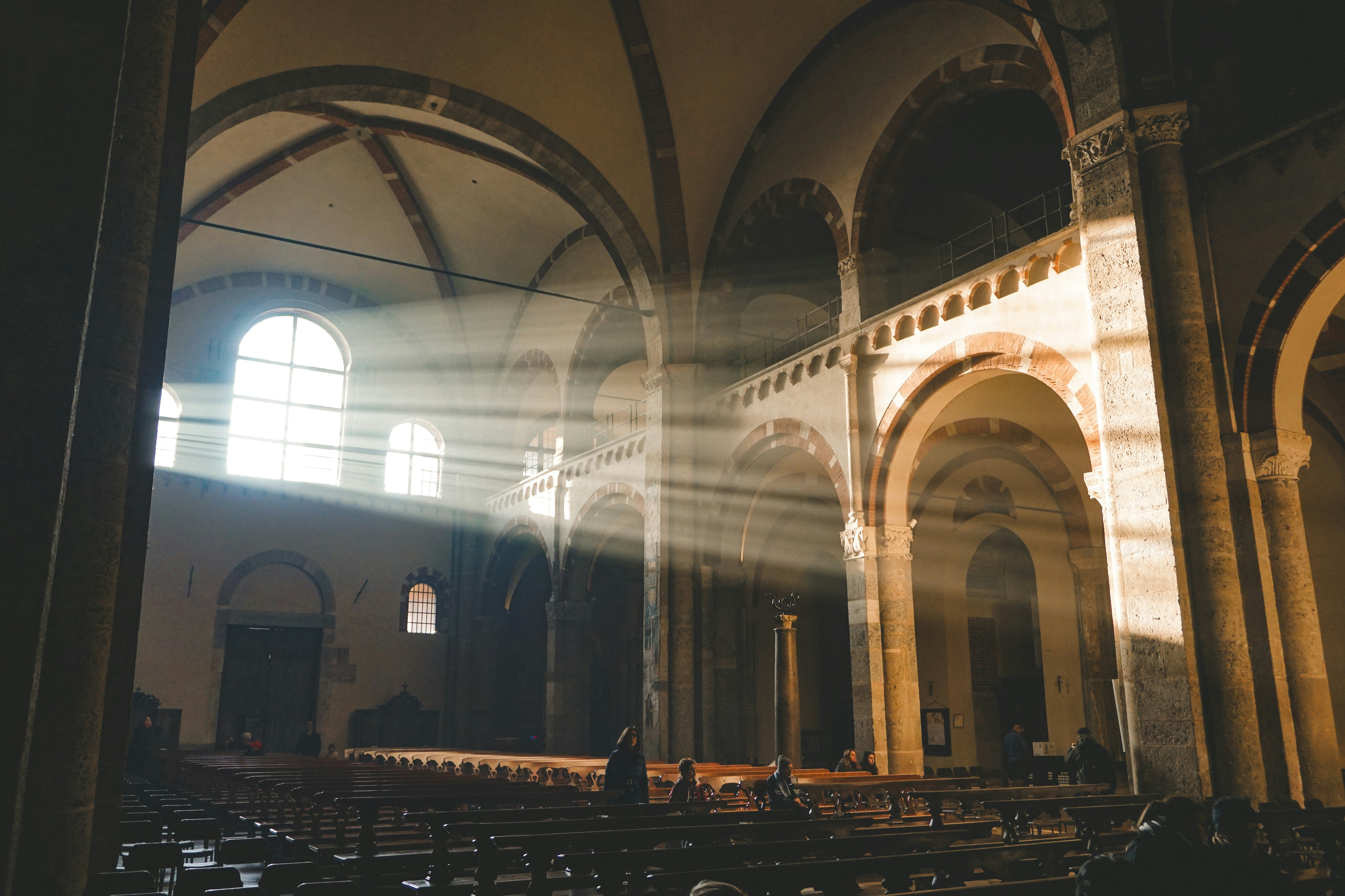 A church filled with lots of pews under a window photo – Free Light ...