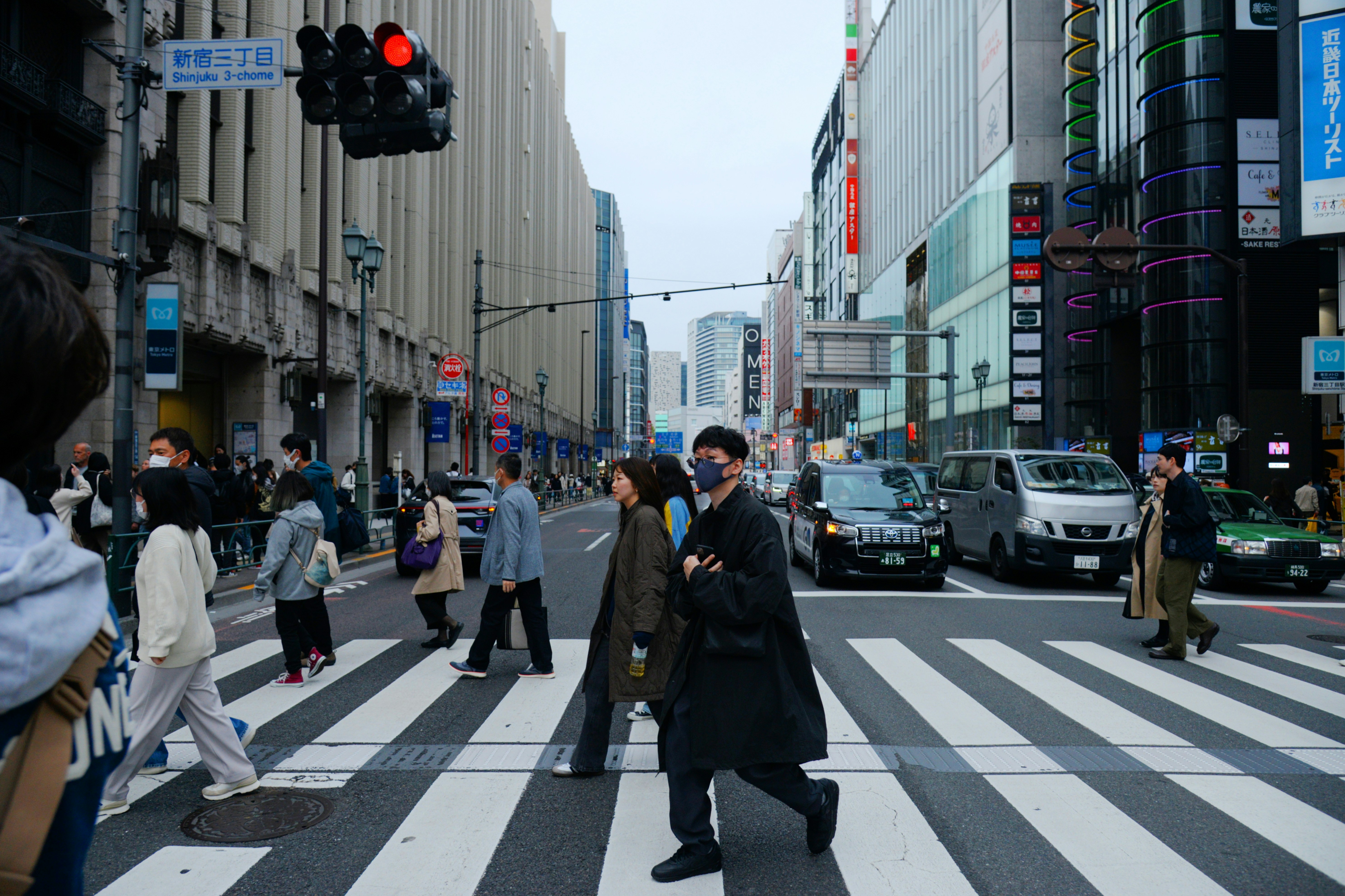 A group of people walking across a cross walk photo – Free Street ...