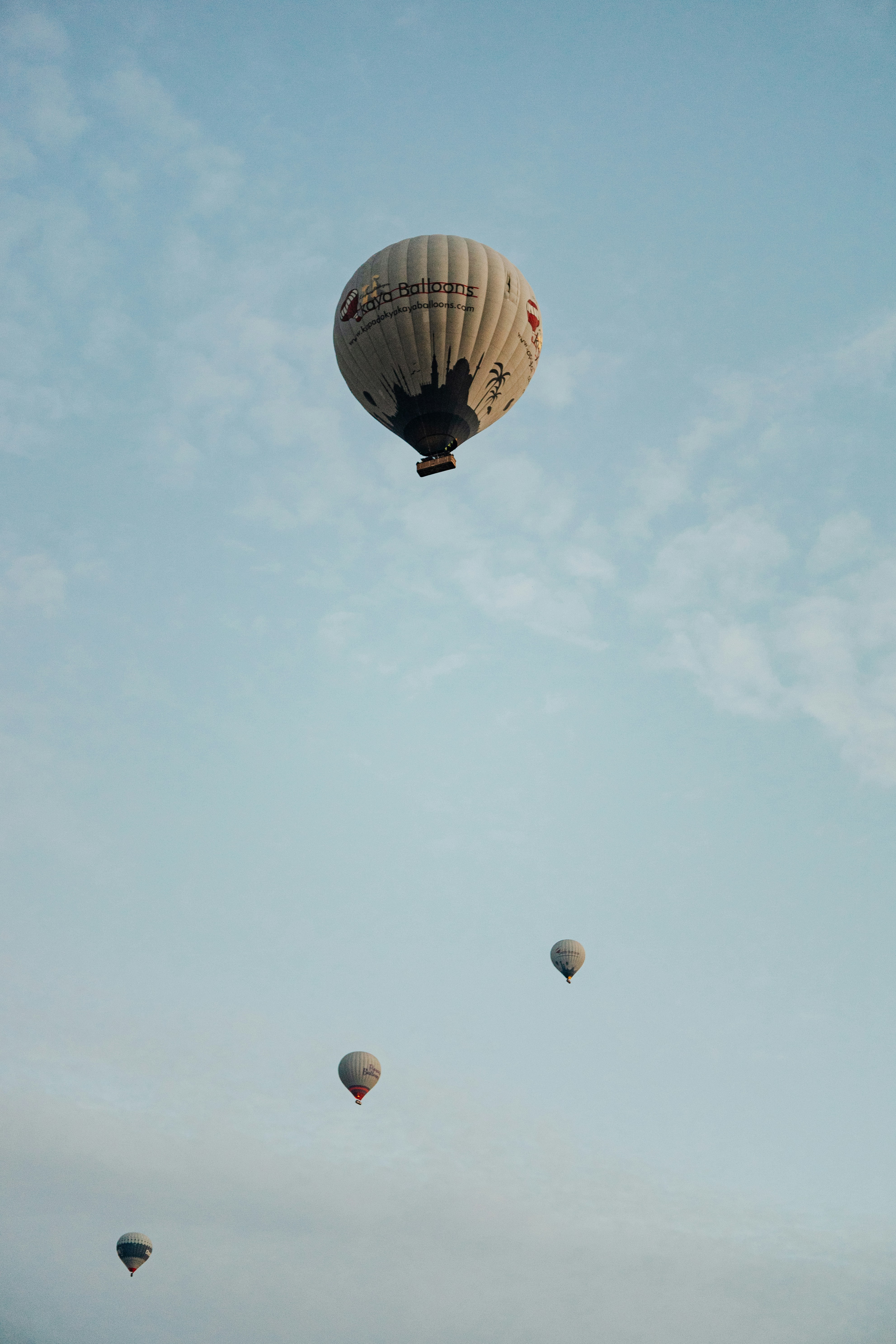 Balloon Serenade: A Giant Beacon Leads a Trio Across a Calm Morning Sky