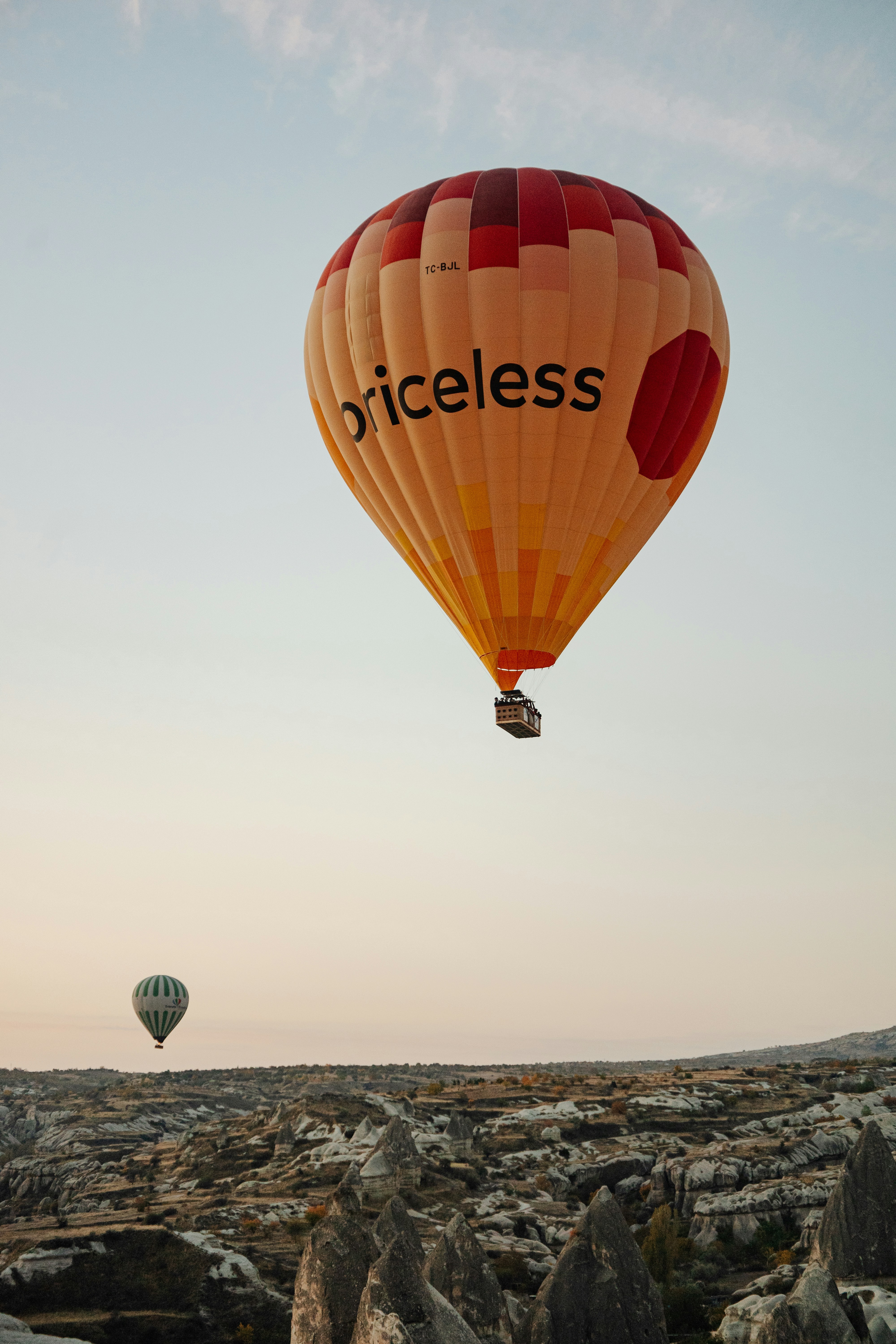 A hot air balloon flying over a rocky landscape photo – Free Göreme ...