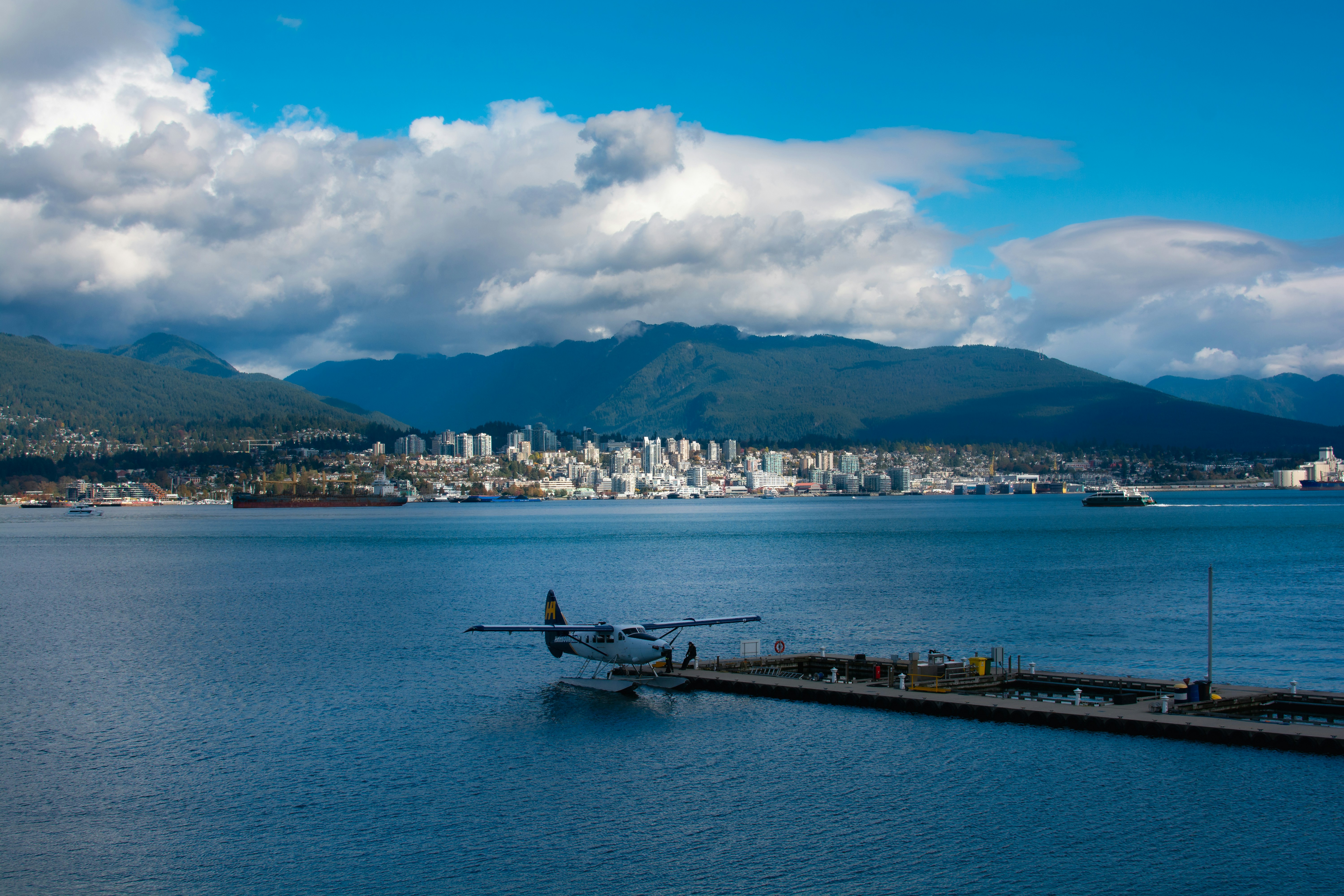 Pierbound Seaplane Amid Blue Harbor and Mountain Backdrop