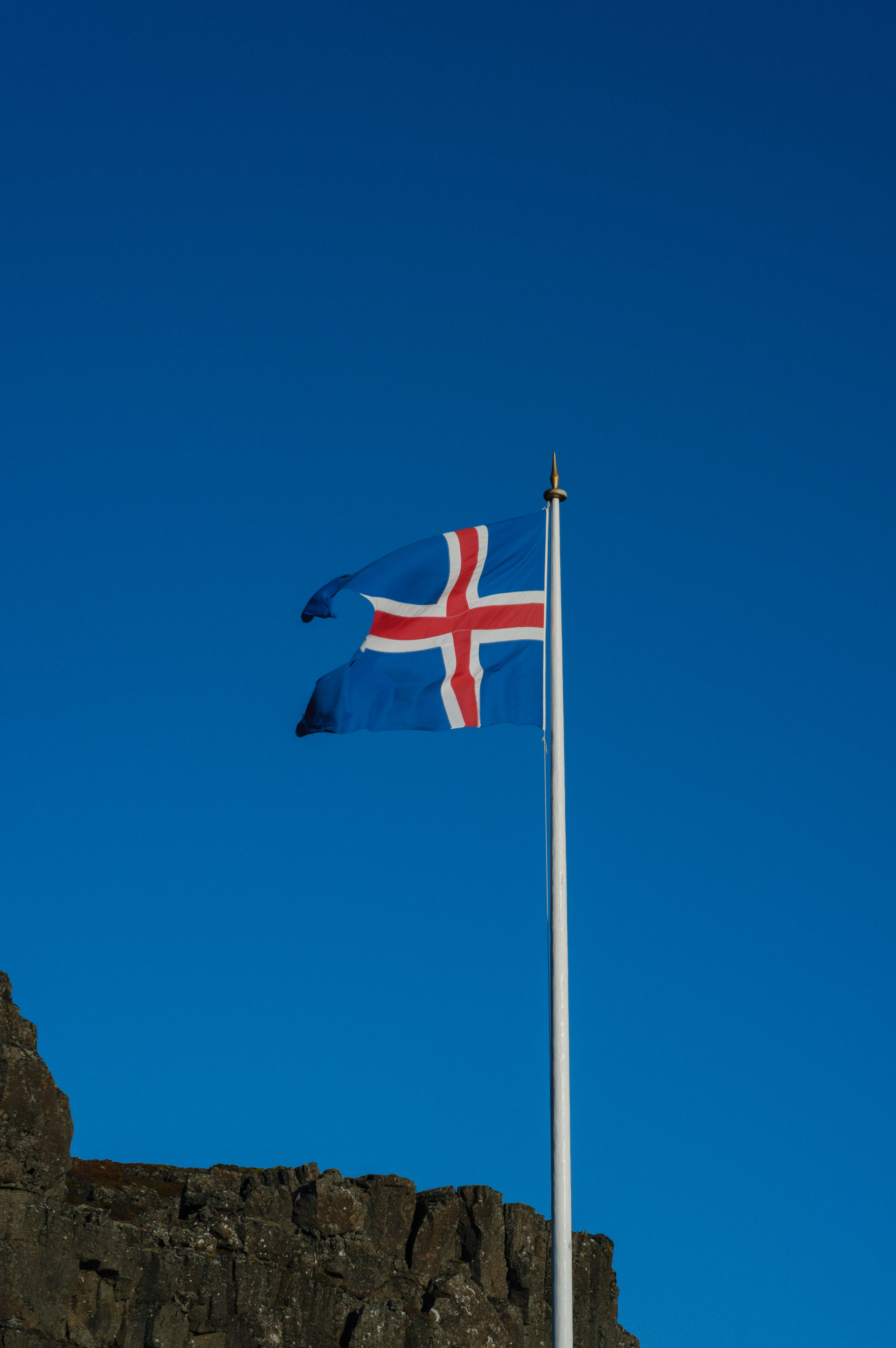 Flag on a Wind-Swept Pole Against a Cobalt Icelandic Sky