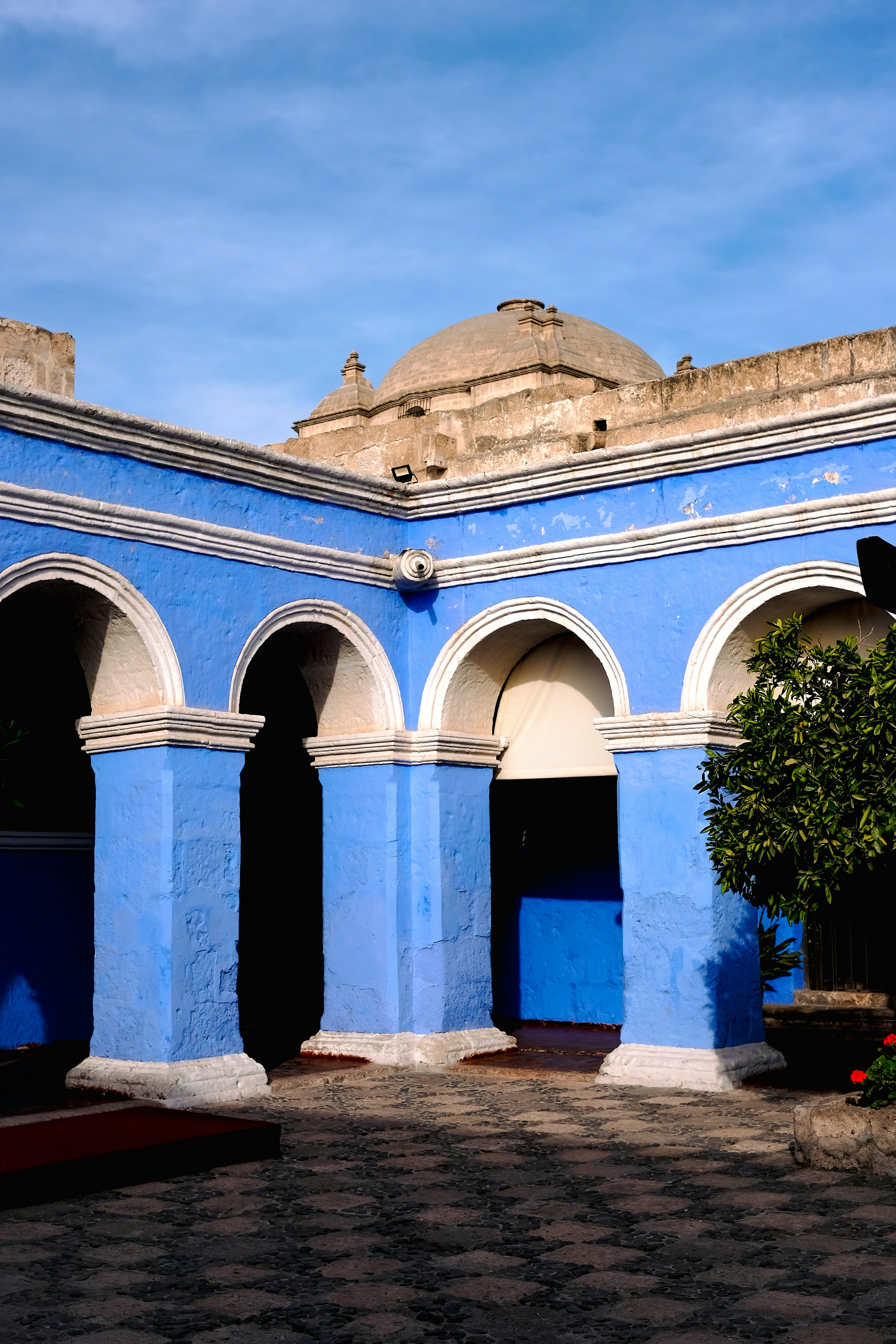 Un edificio azul con arcos y arcos a su alrededor foto – Imagen de Edificio gratuita en Unsplash