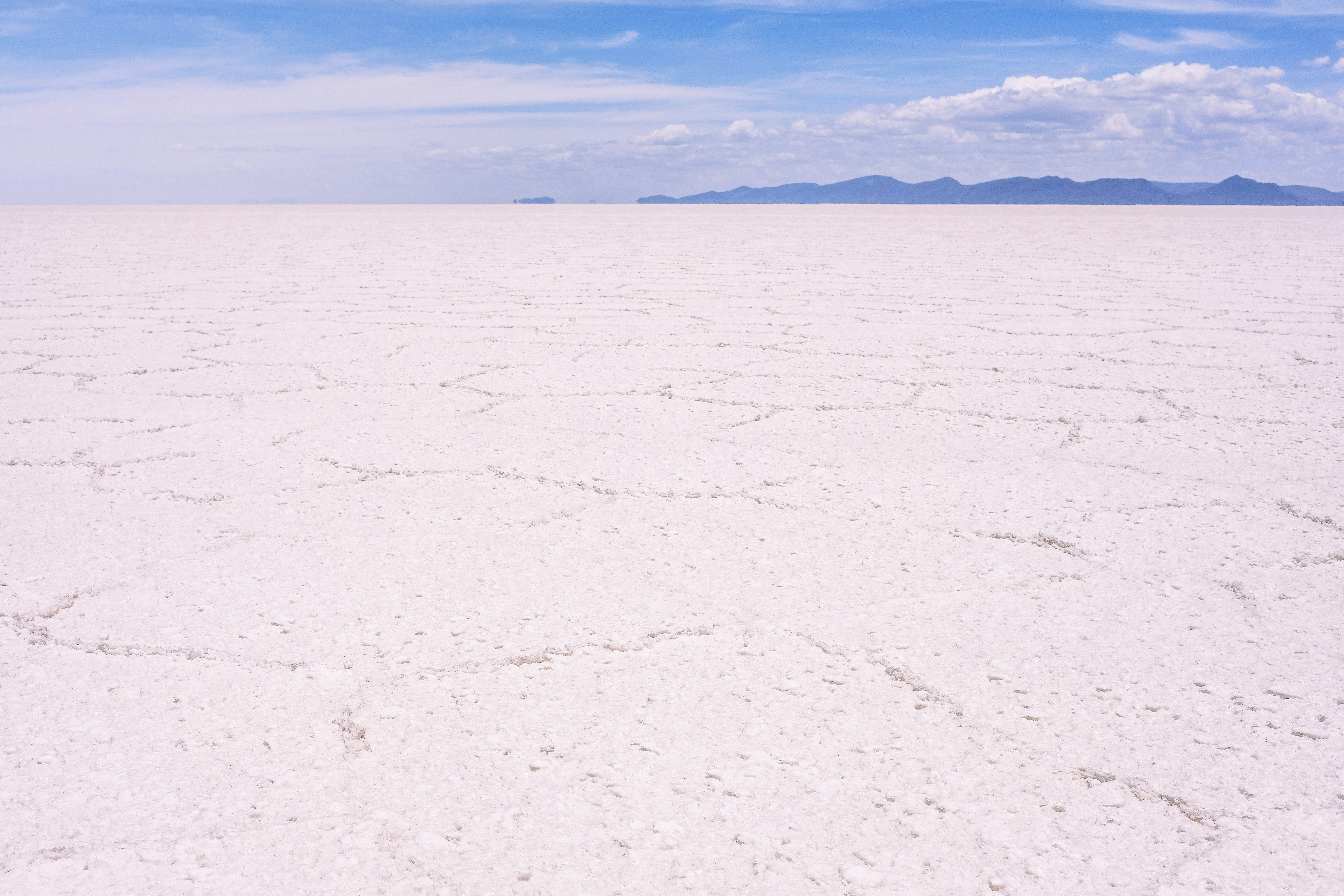 Salt-Lace Horizon: Cracked Ground Meeting a Pale Blue Sky