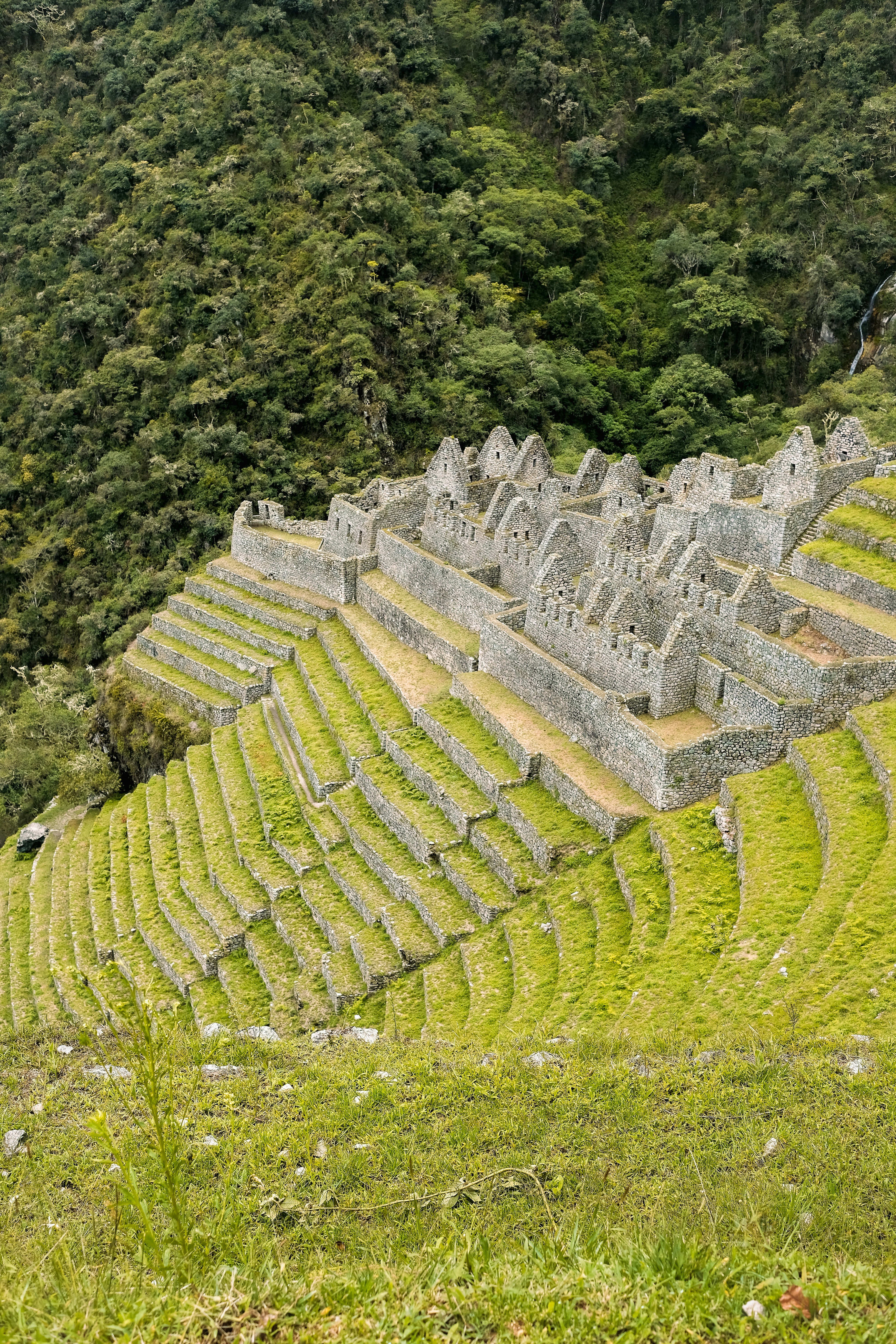 A large stone structure sitting on top of a lush green hillside photo ...