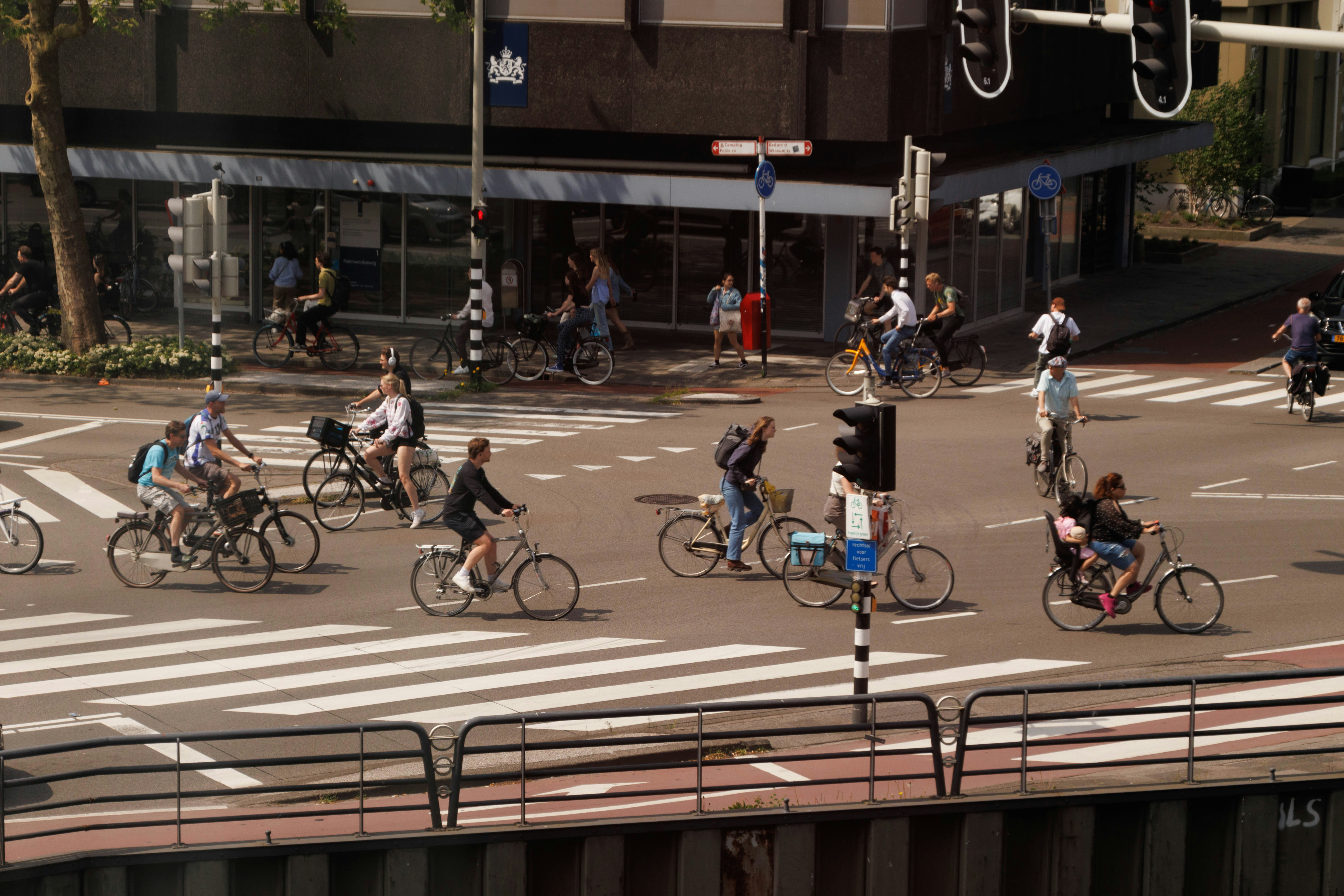 Cyclists navigating a busy intersection on a sunny day.