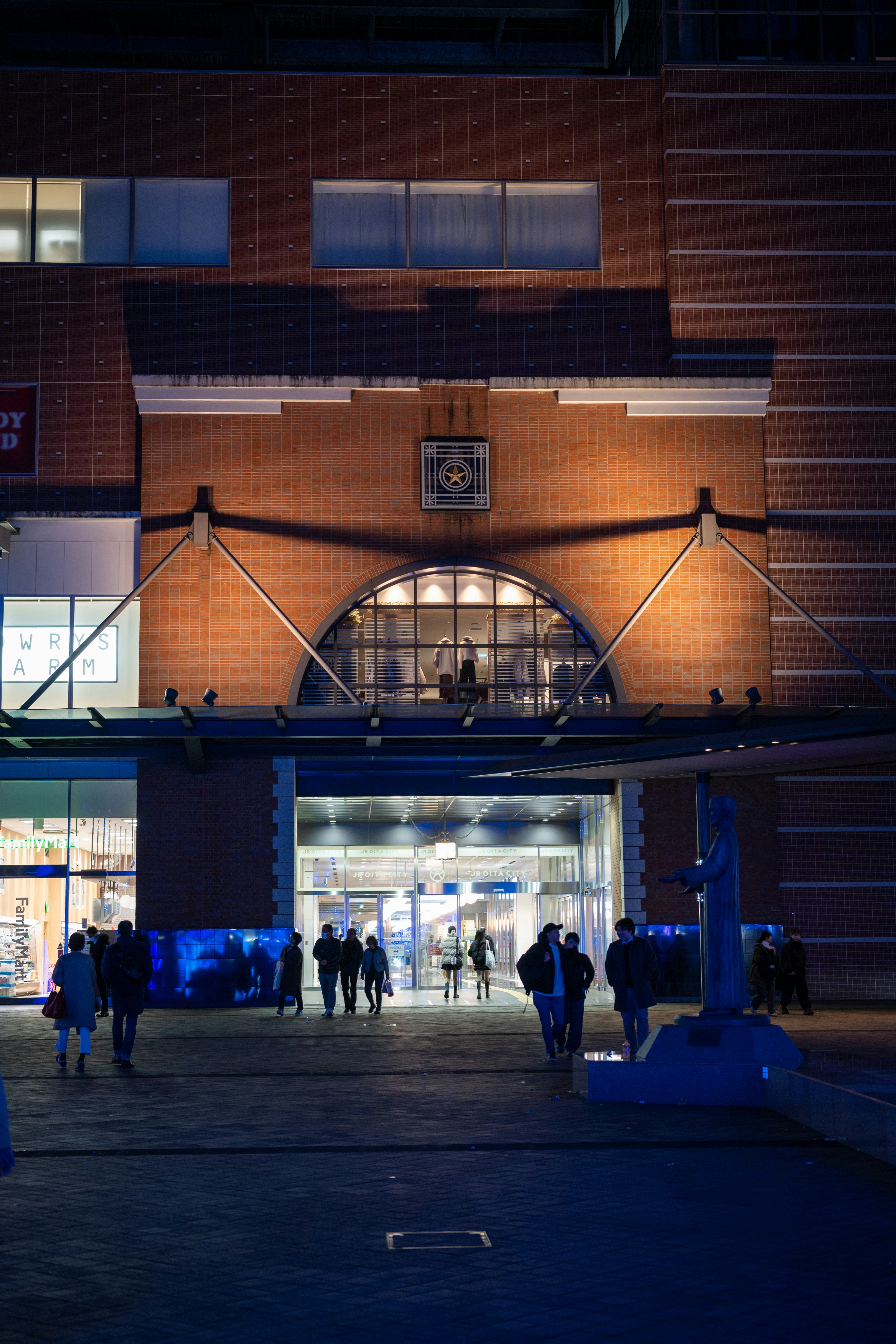 A group of people standing outside of a building at night photo – Free ...