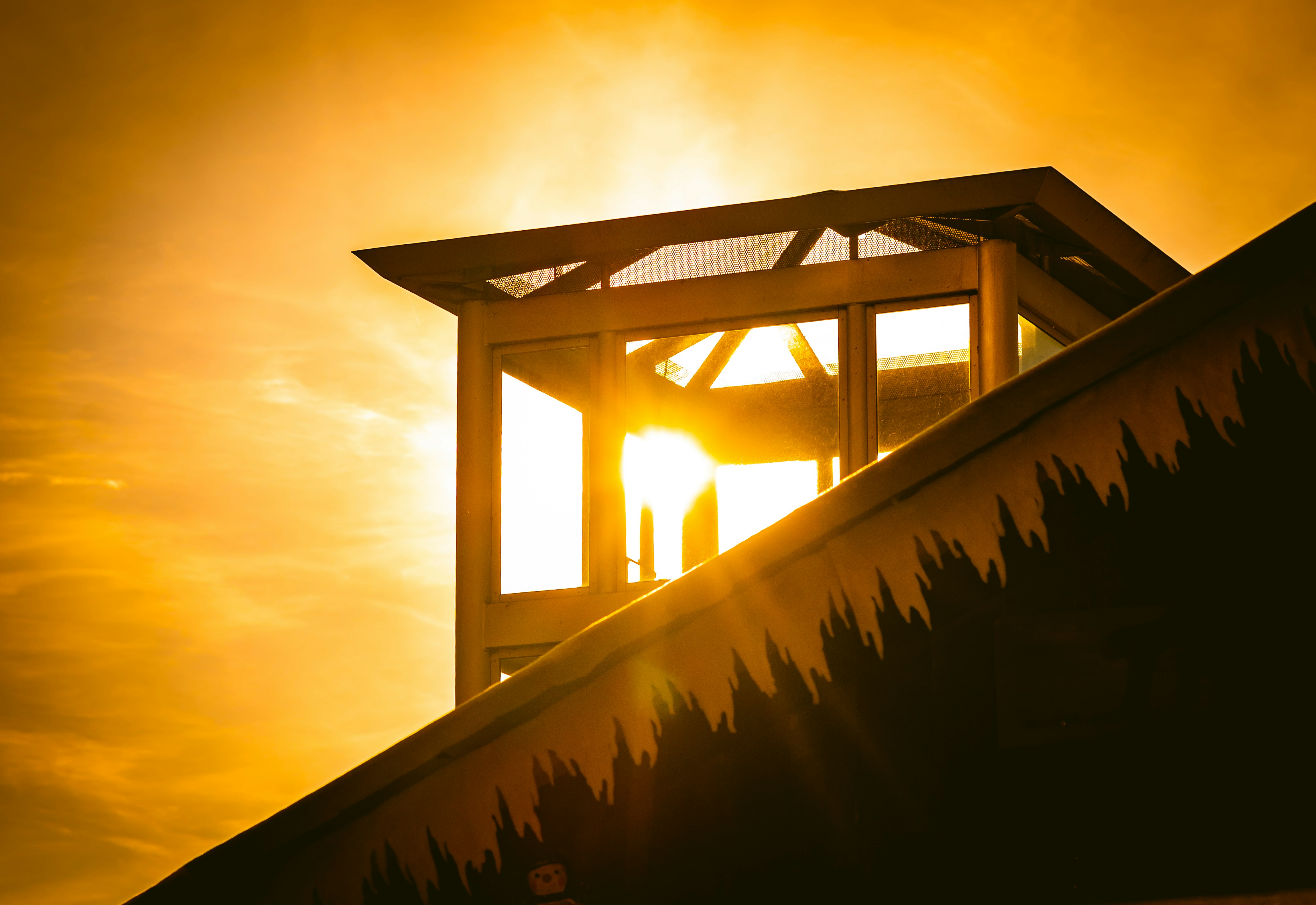 The sun is setting behind a building with a roof photo – Free Bremen ...