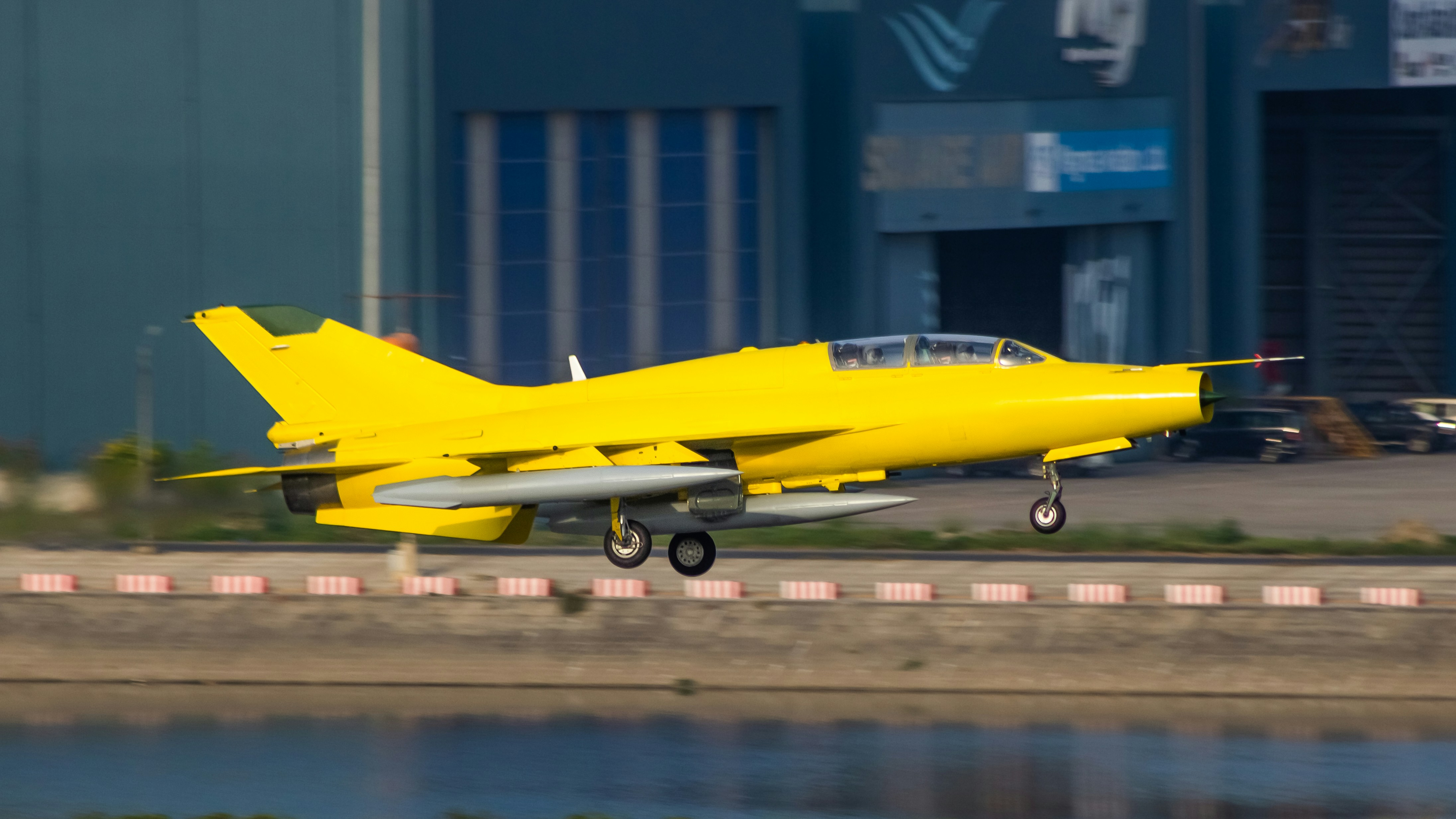 Solar Scout: A Bright Yellow Jet Resting Along a Waterfront Ramp