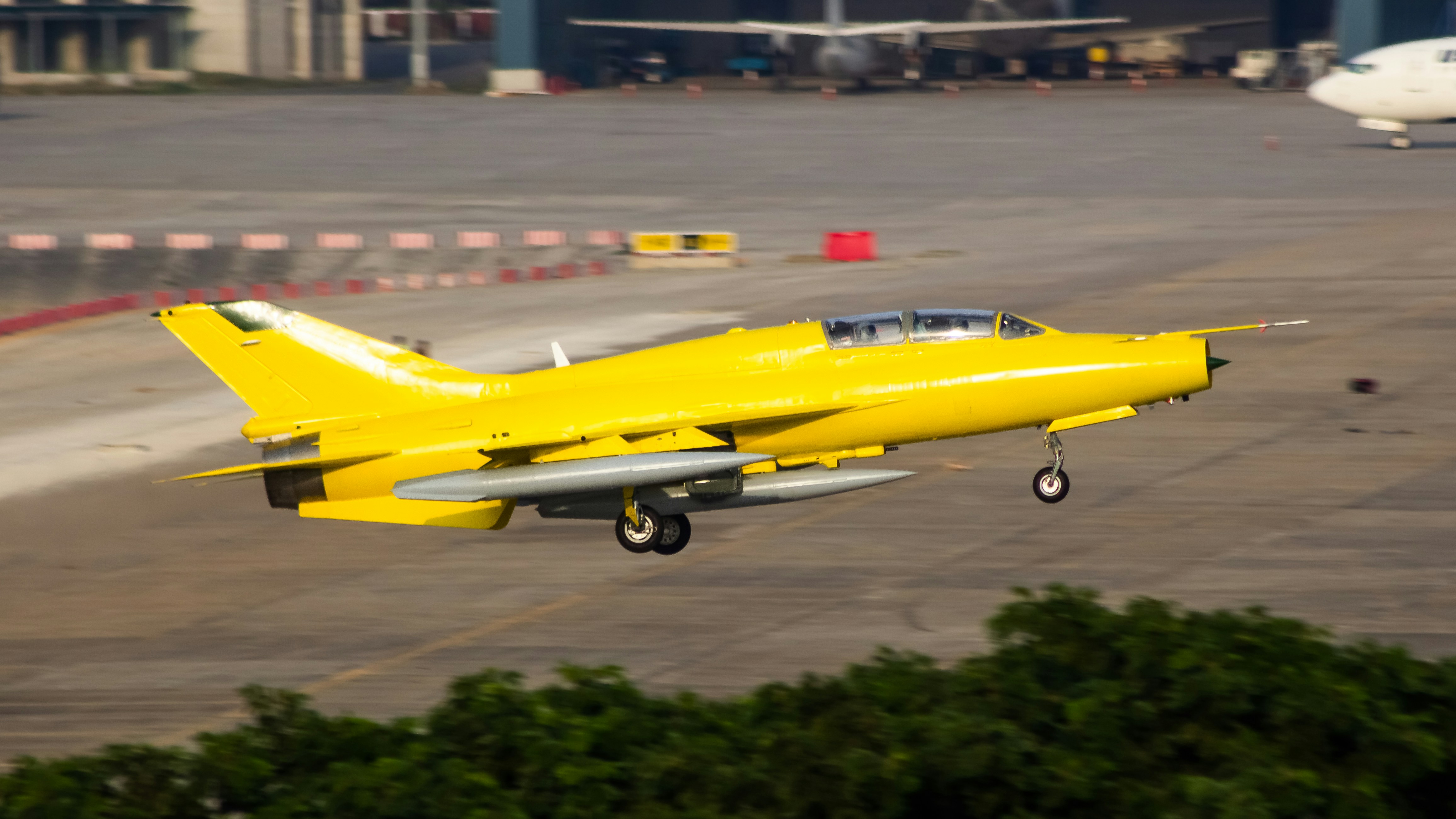 Sunlit Yellow Aerobatic Jet: A Moment of Velocity on the Runway
