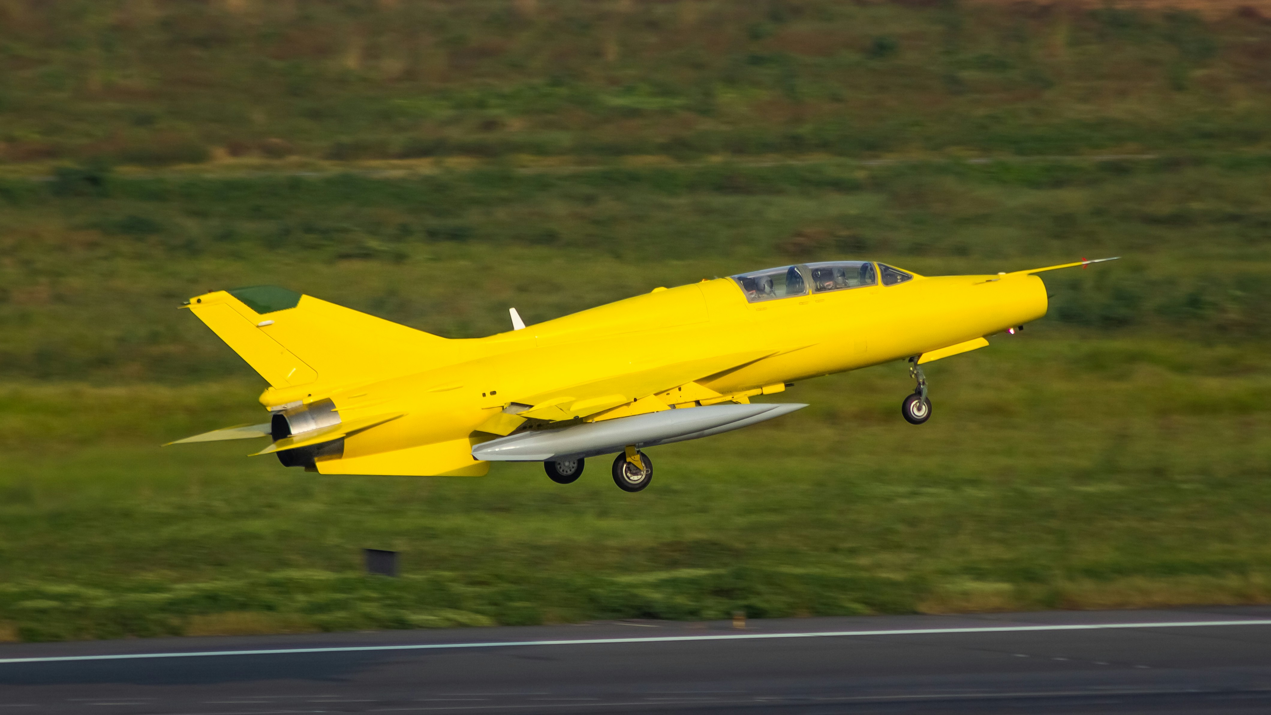 A yellow plane is flying low to the ground photo – Free Fighter jet ...