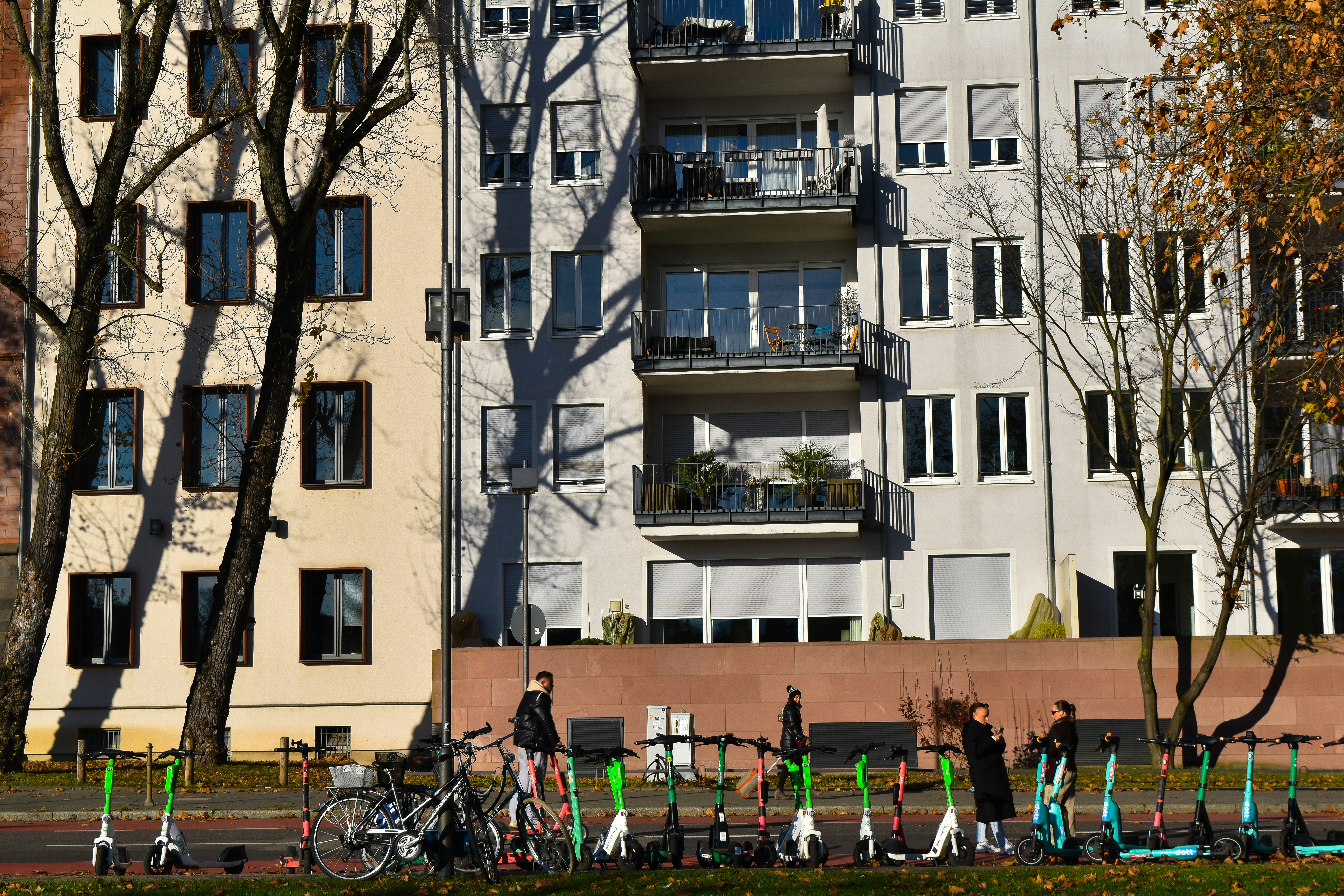 Neon Scooter Row in Front of a Sunlit City Block