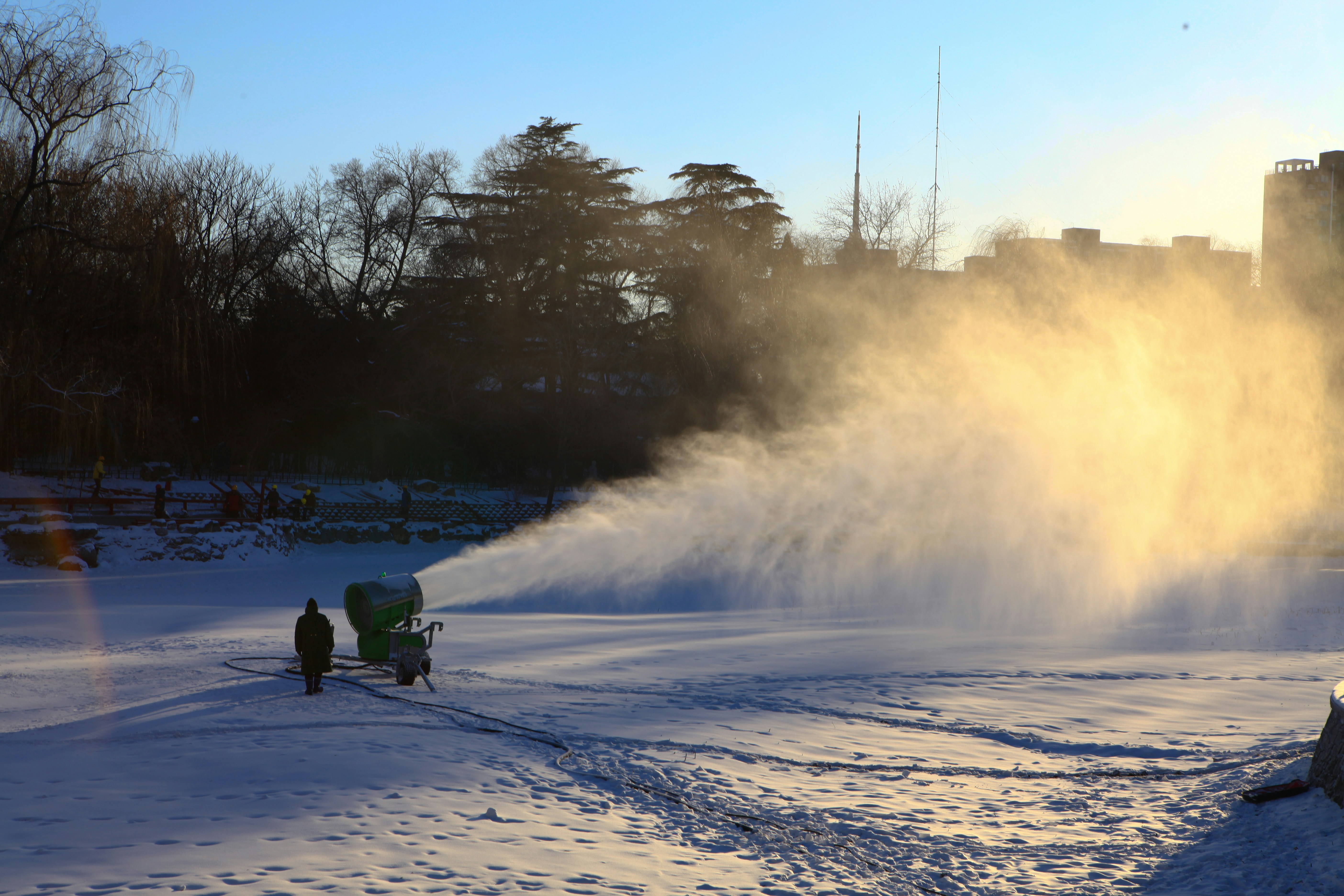 Green Snow Cannon in Golden Hour: Precision at a Snowfield Park