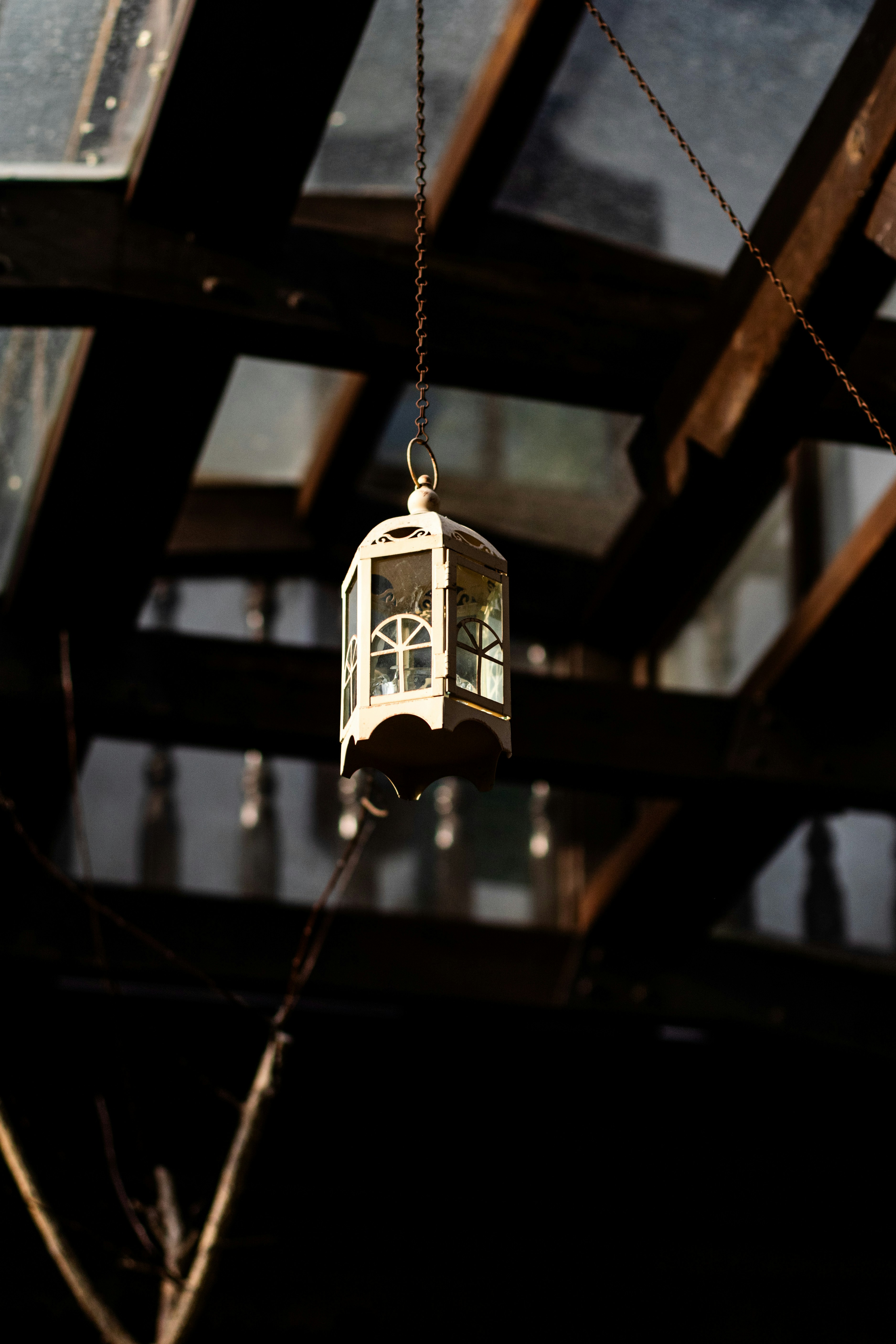 Amber Lantern Quietly Suspended Under a Glass Atrium