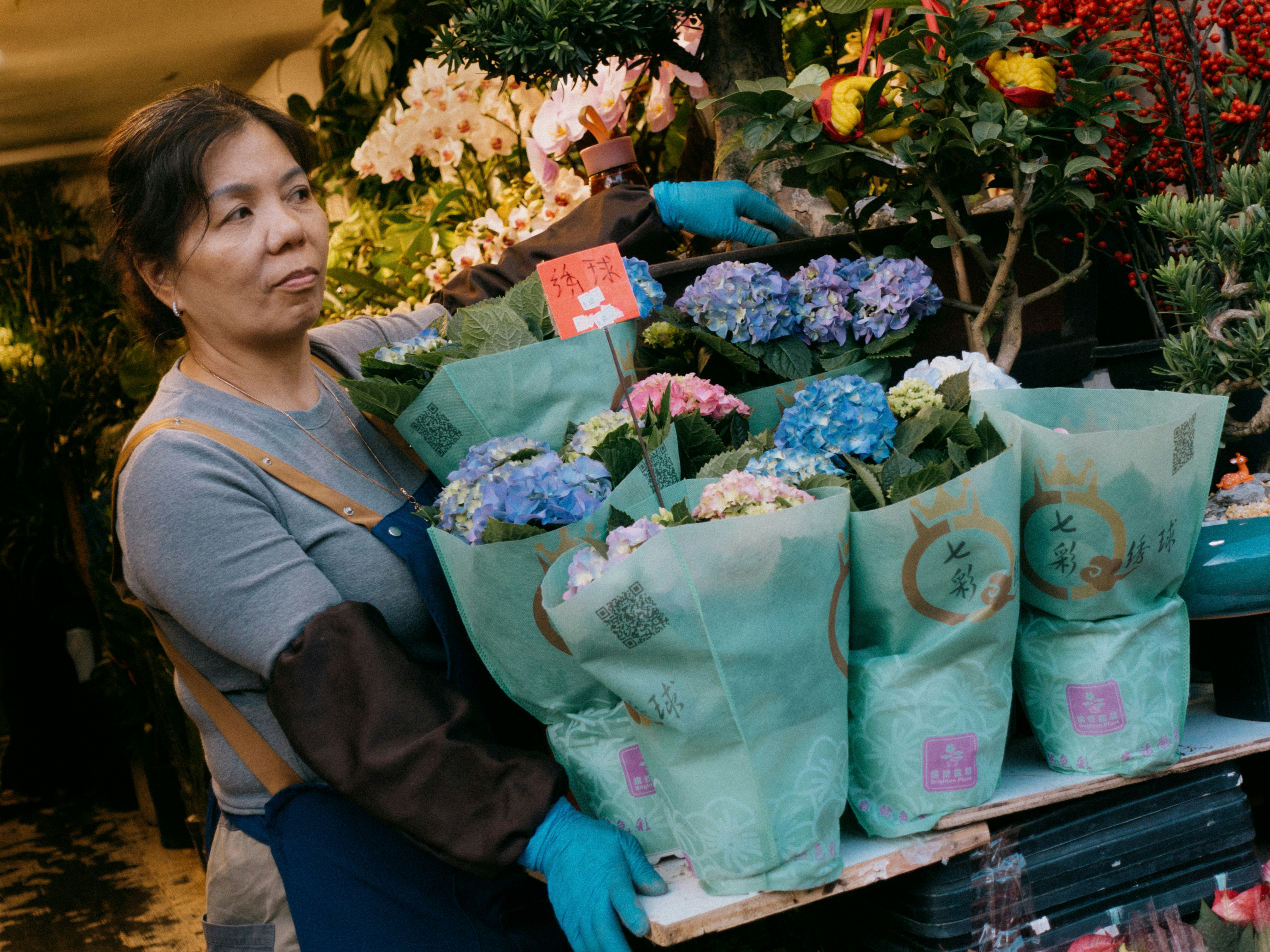 Floral Vendor with Turquoise Bouquets in a Busy Market Stall