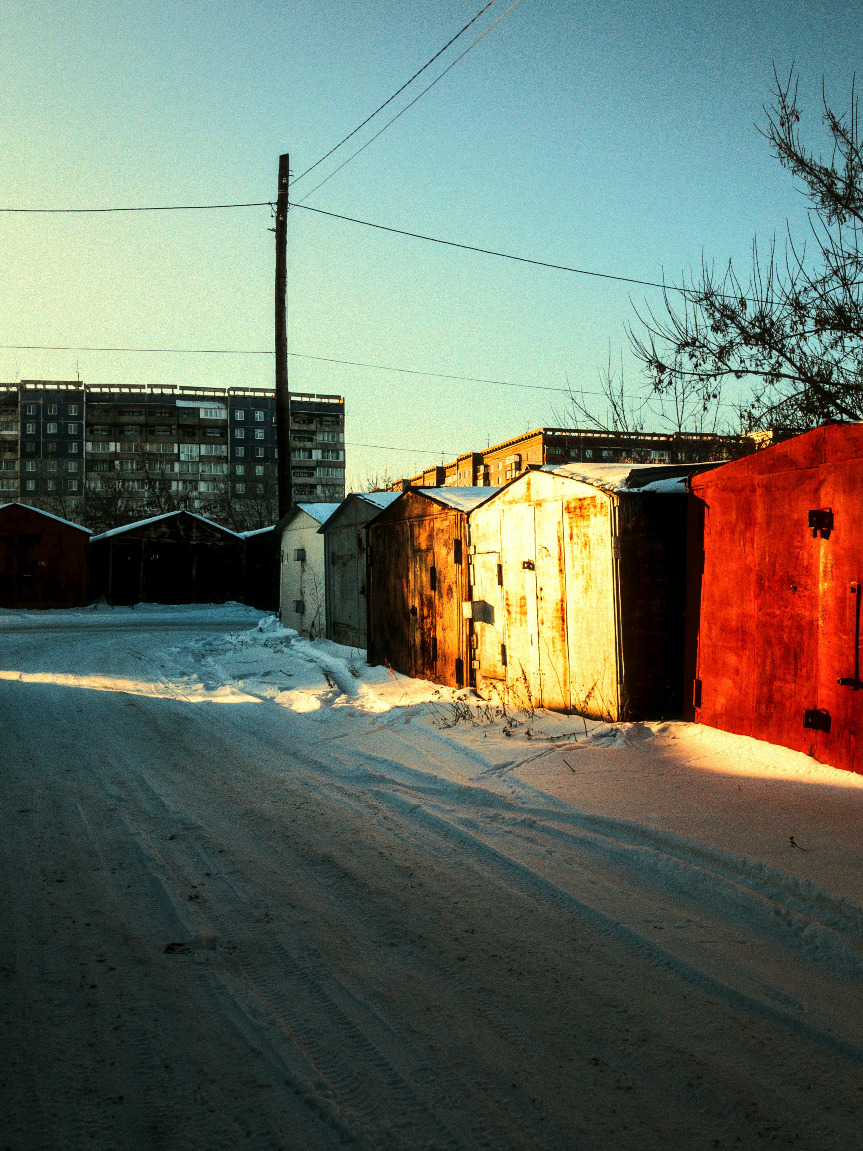 Gilded Garages Dusted with Snow in a Sunset Alley