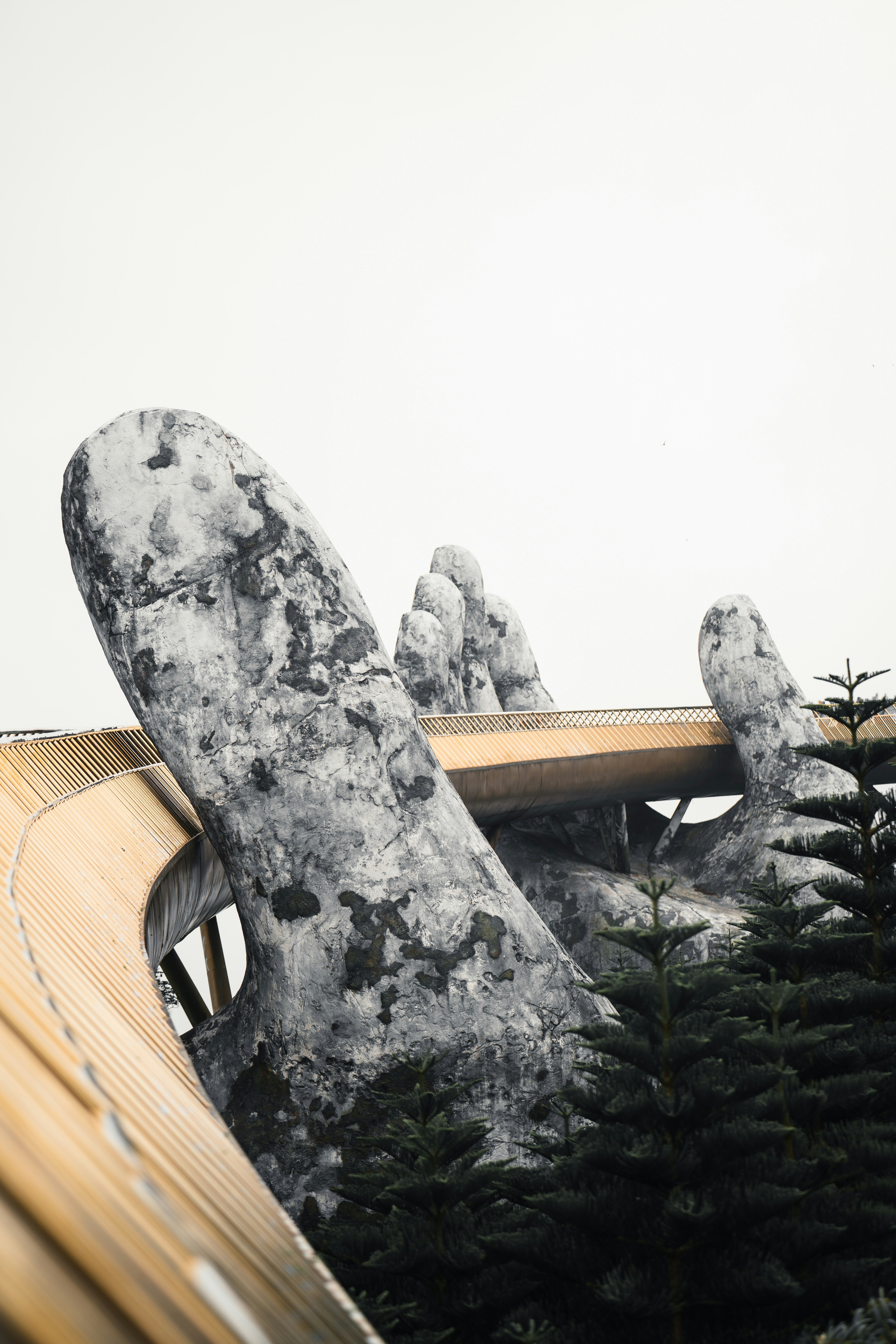 Stone Fingers Embrace a Curved Wooden Bridge