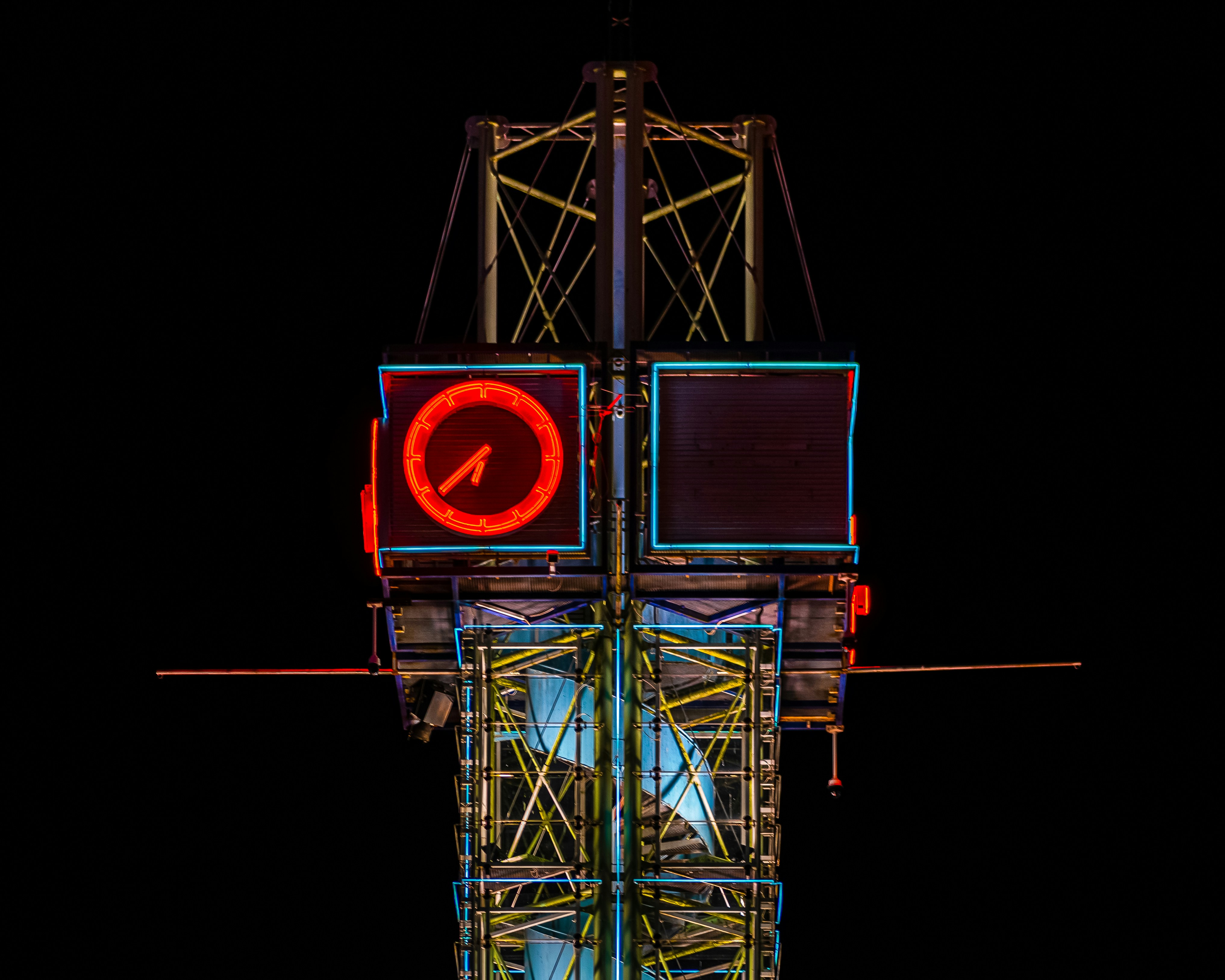 Neon Clockwork Tower: Red Dial Above a Night-Shrouded Steel Frame