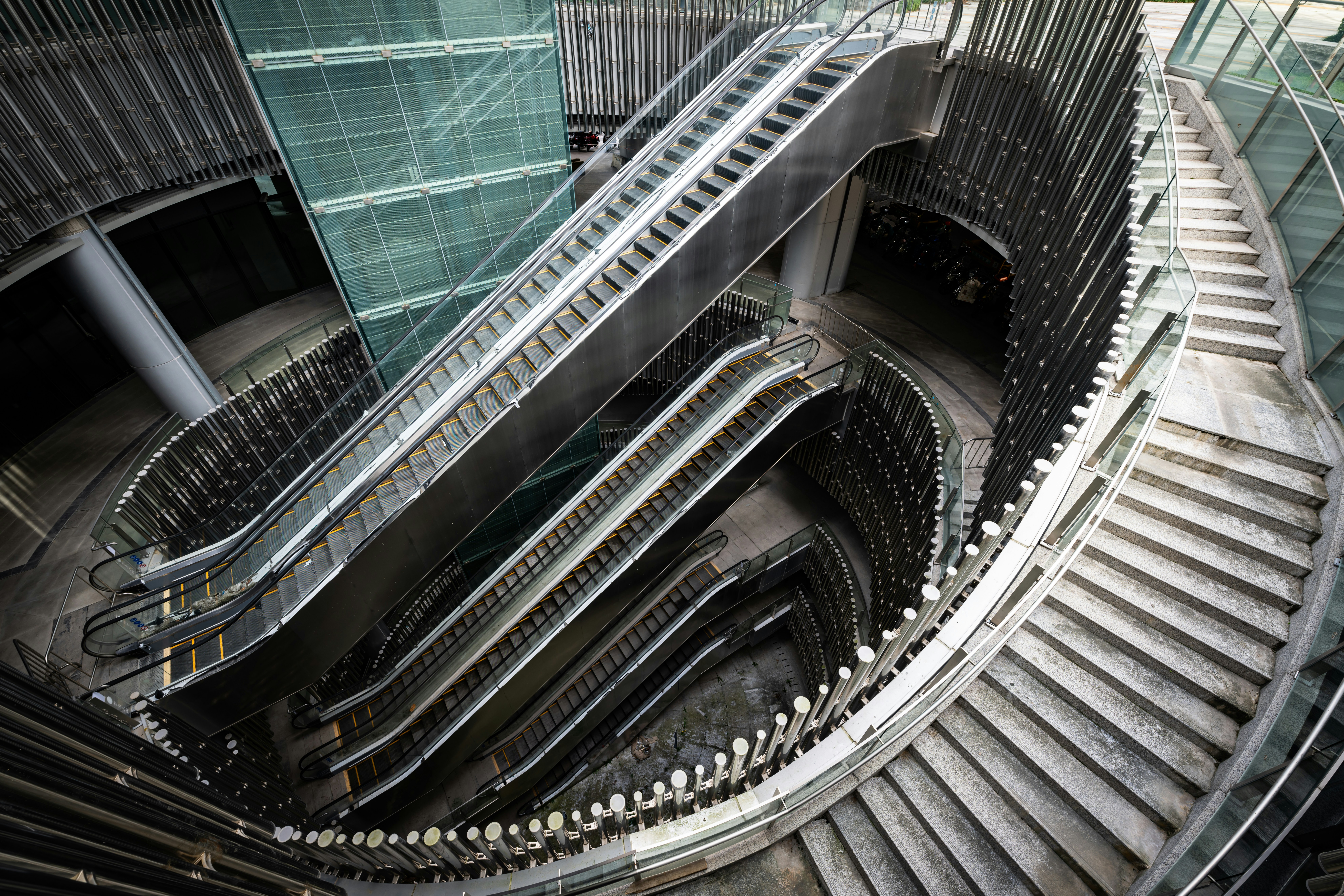 An escalator in a building with a spiral staircase photo – Free Xuhui ...