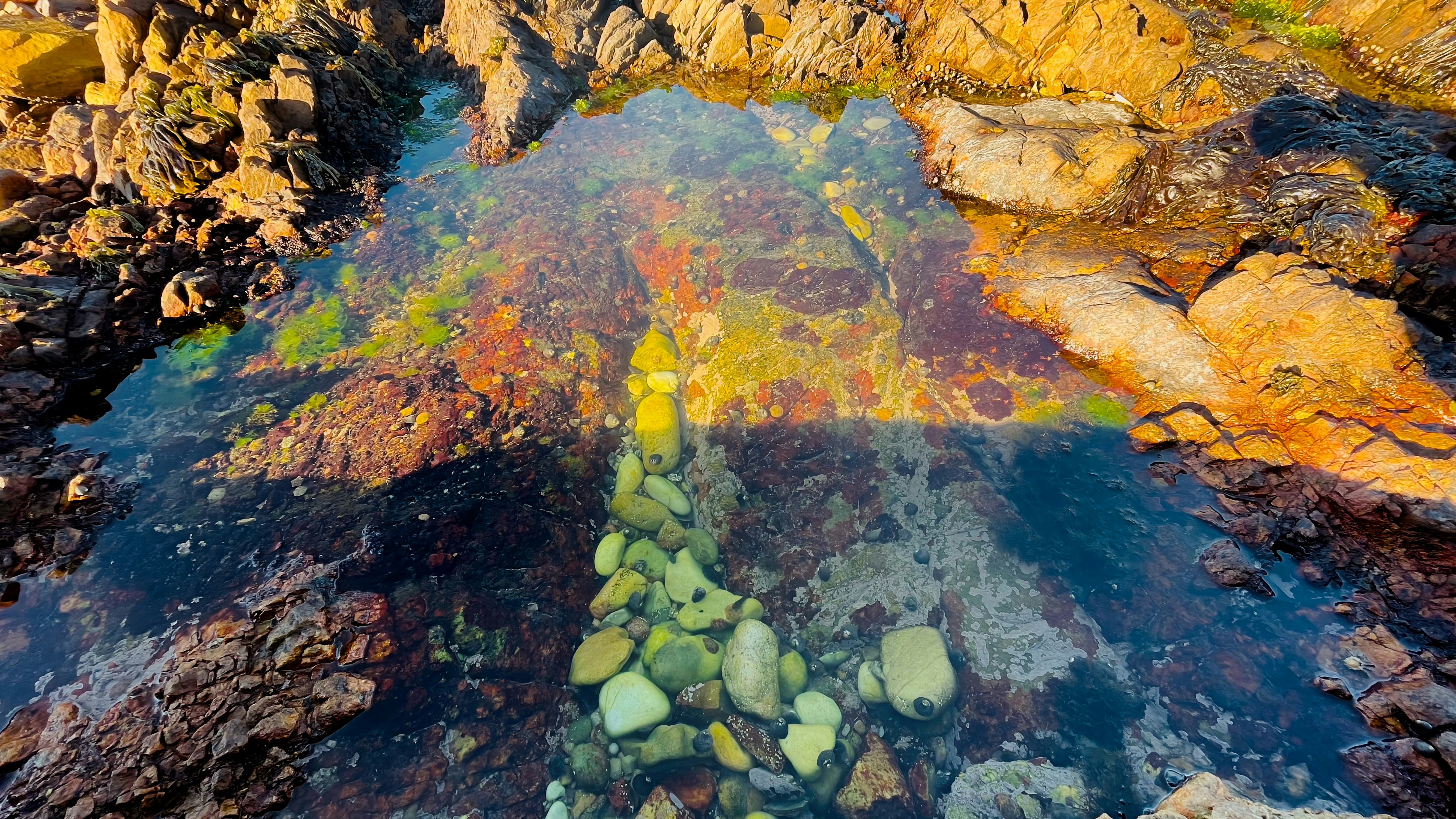 A large body of water surrounded by rocks photo – Free Gansbaai Image ...